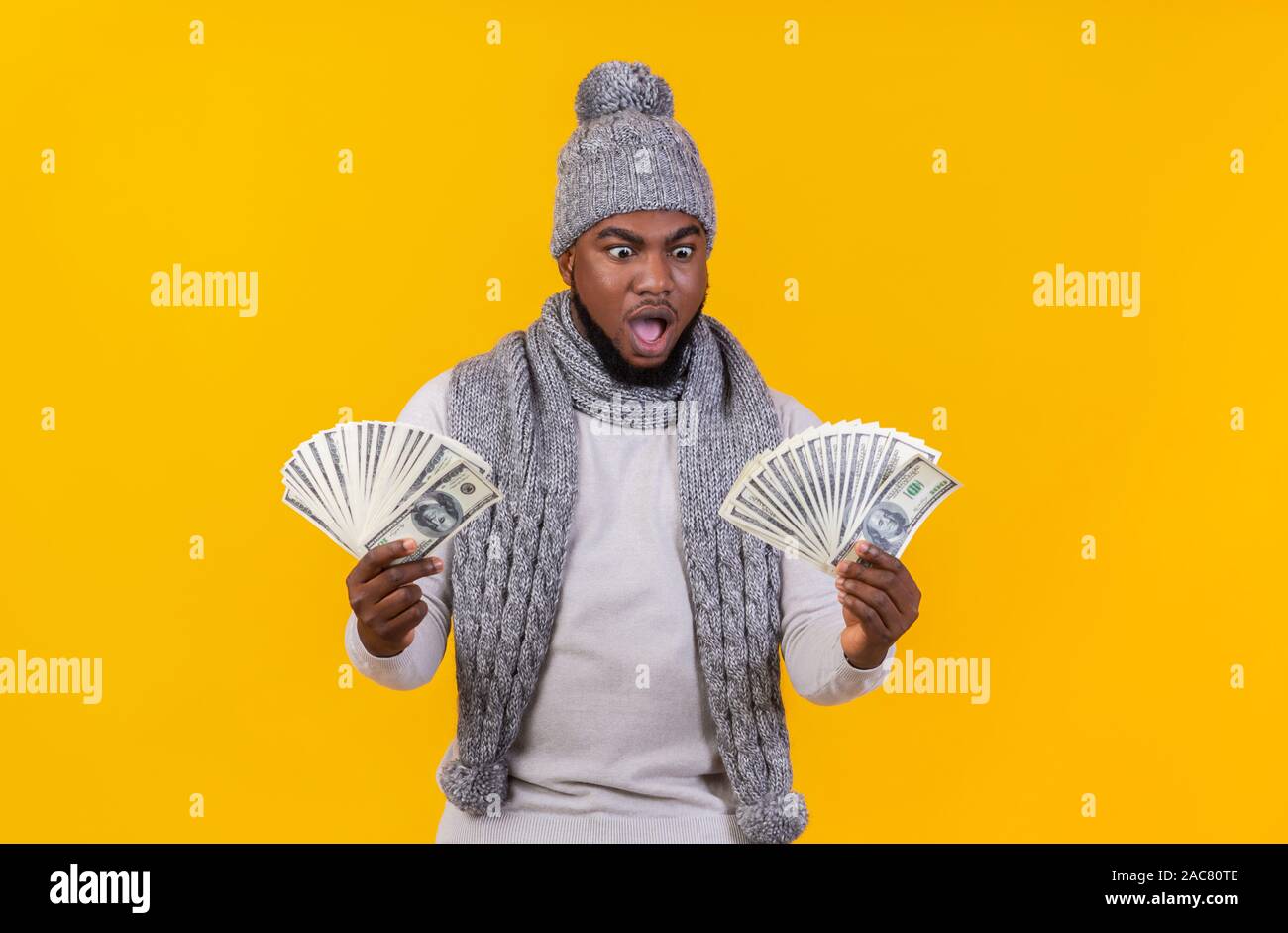 Shocked black man looking at money in his hands Stock Photo - Alamy
