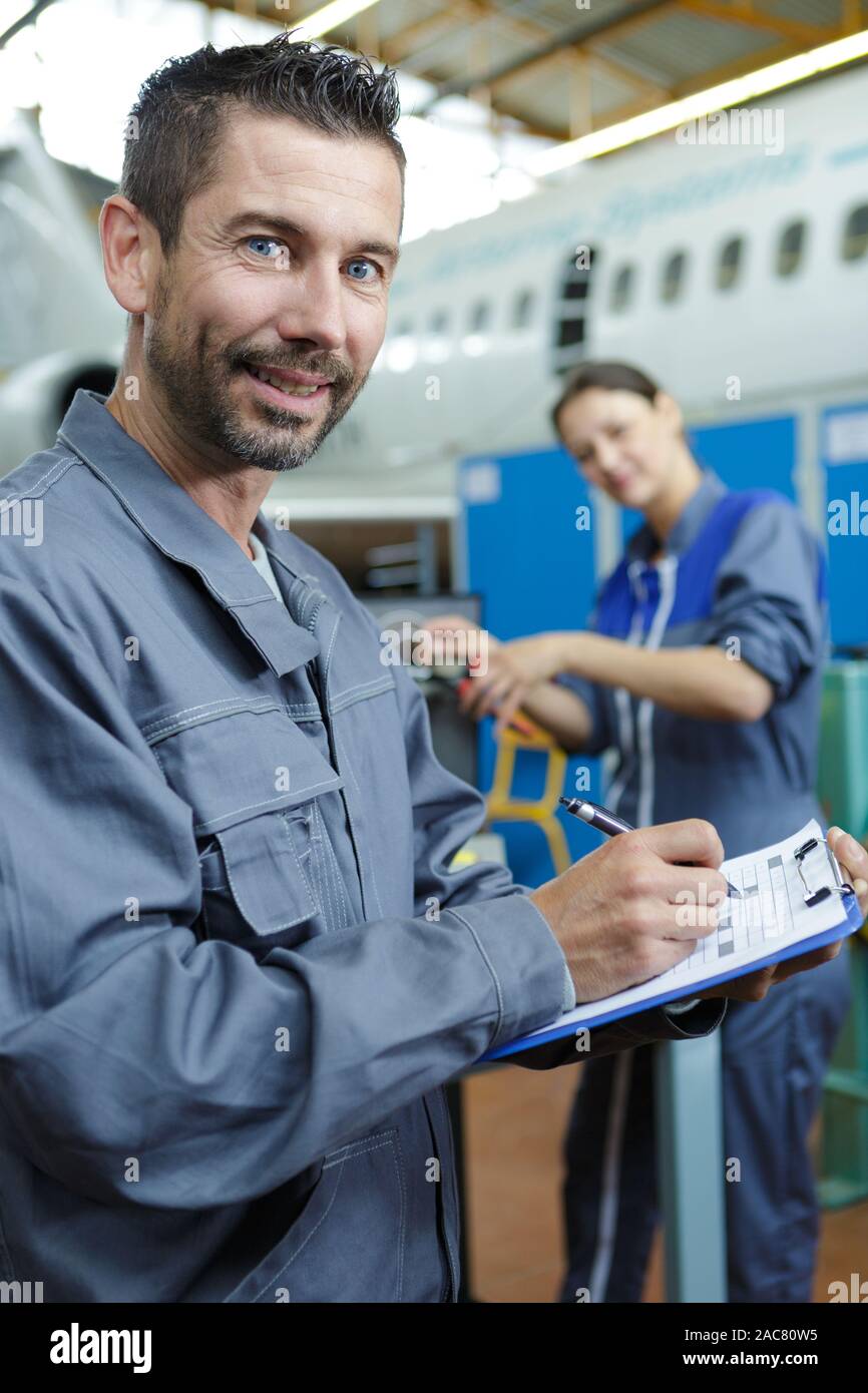 mechanic with clipboard looking at camera Stock Photo - Alamy