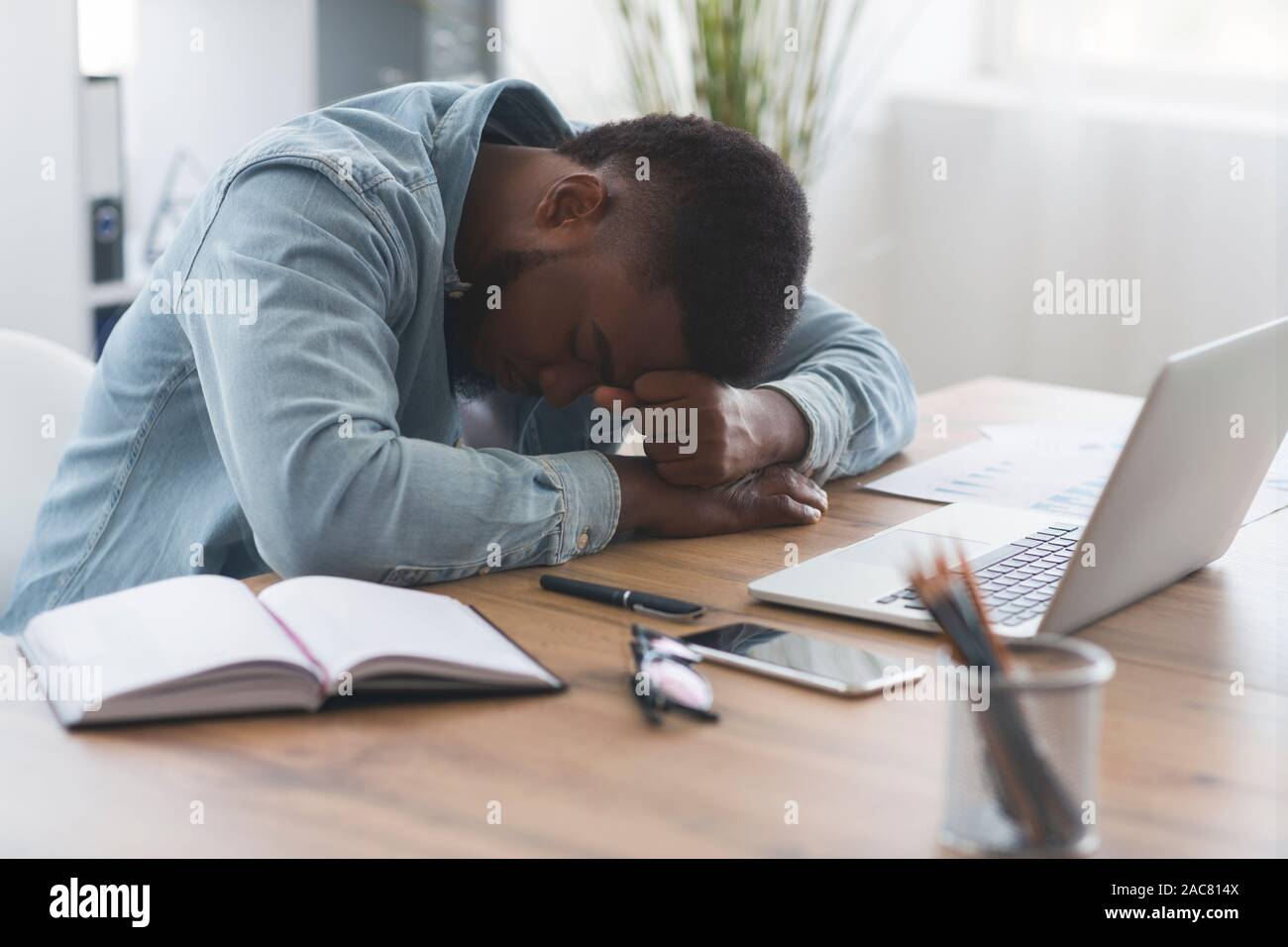 Exhausted black businessman napping at workplace in office Stock Photo ...