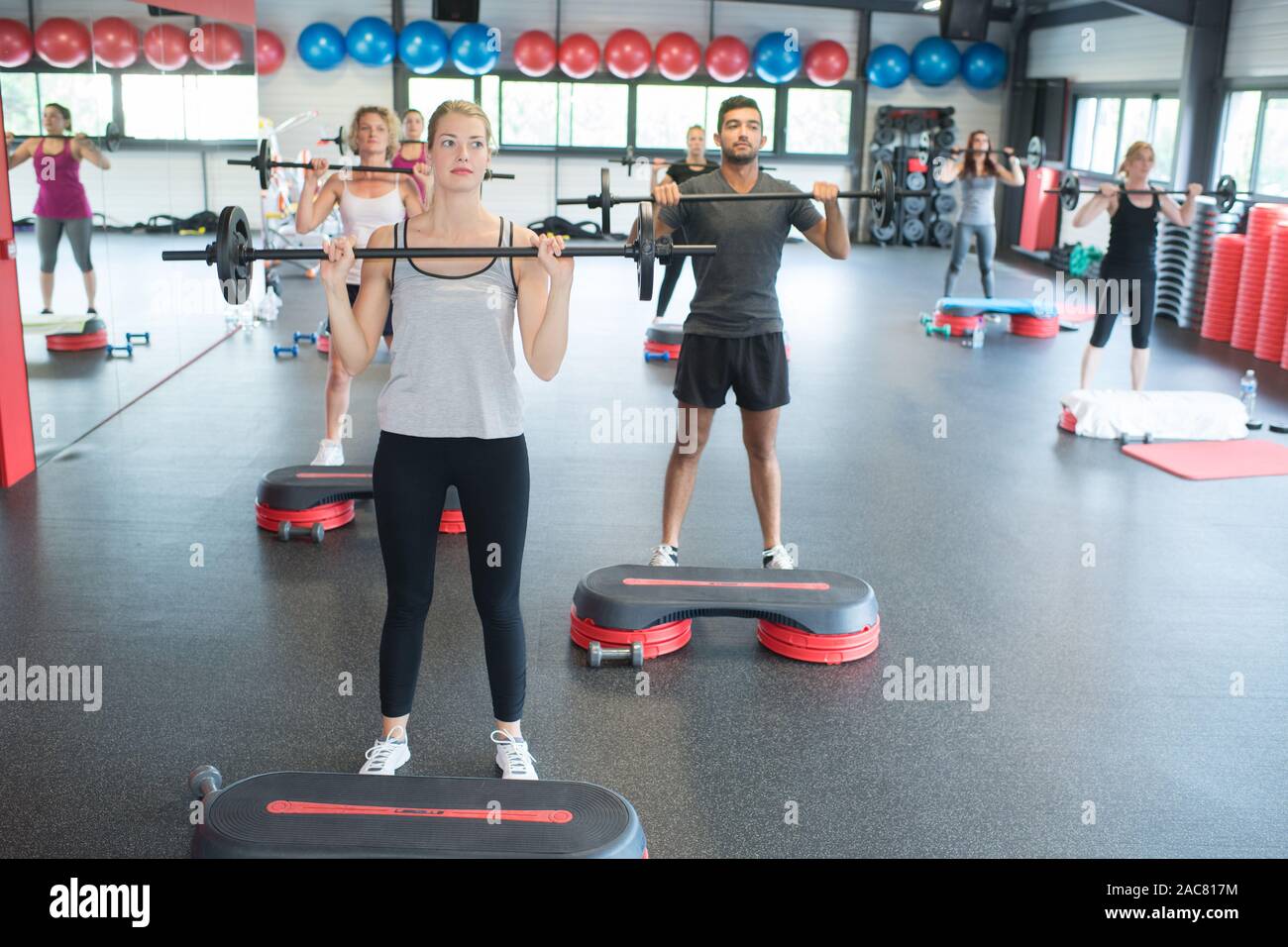 group of people excercising with bars in gym Stock Photo - Alamy