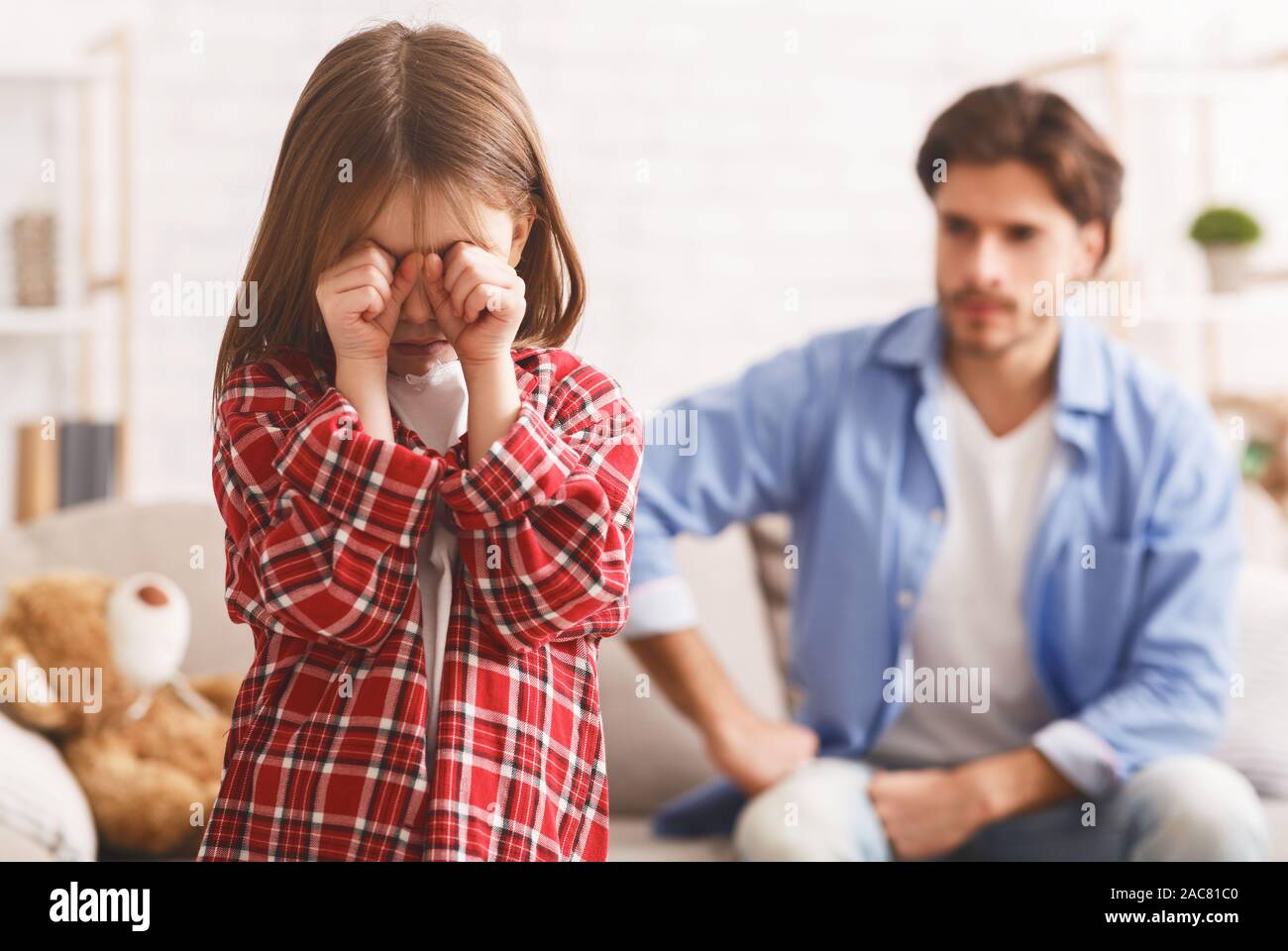 Little girl crying after arguing wIth dad, angry father behind Stock ...