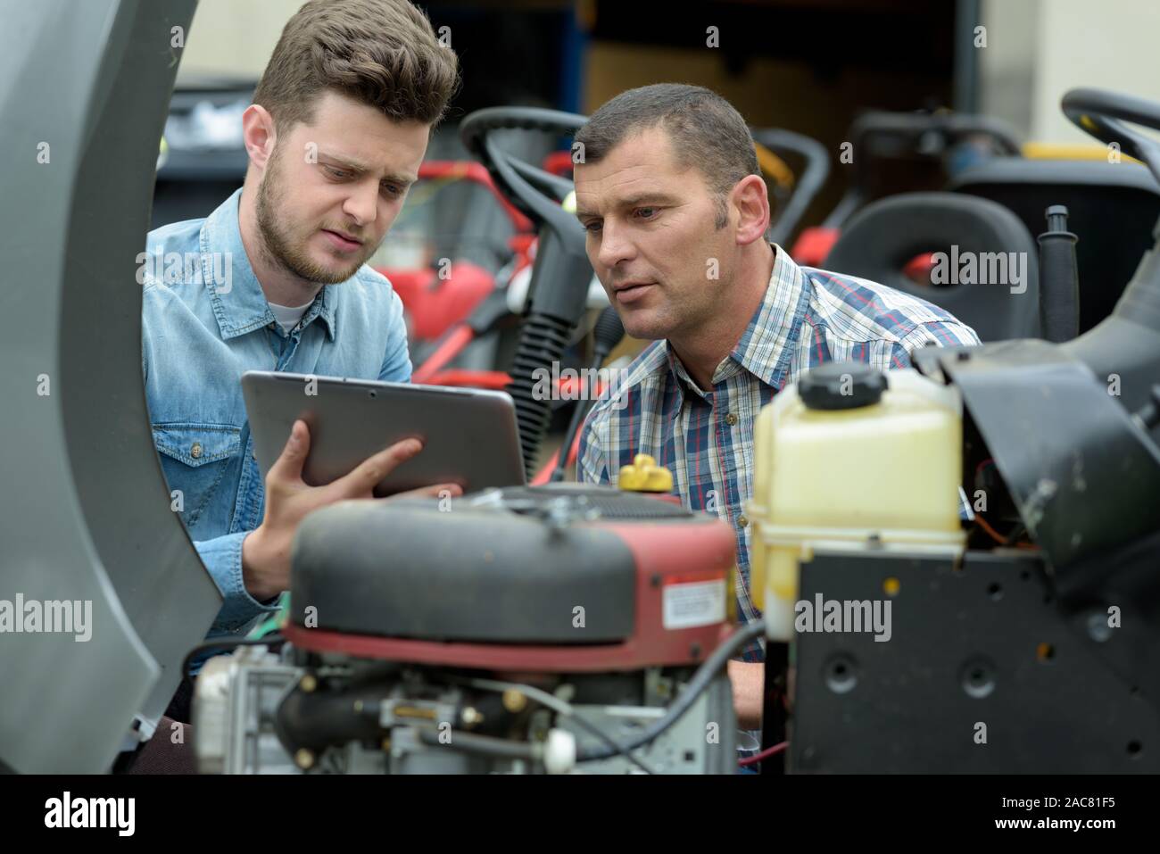 portrait of men fixing a lawn mower Stock Photo - Alamy