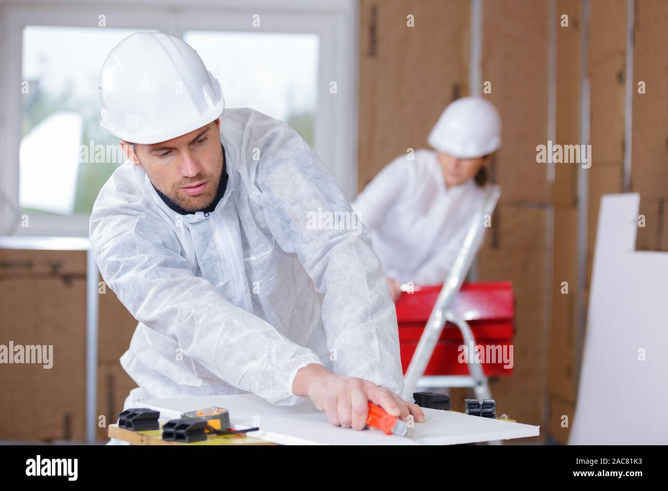 handsome worker using saw at construction site Stock Photo - Alamy