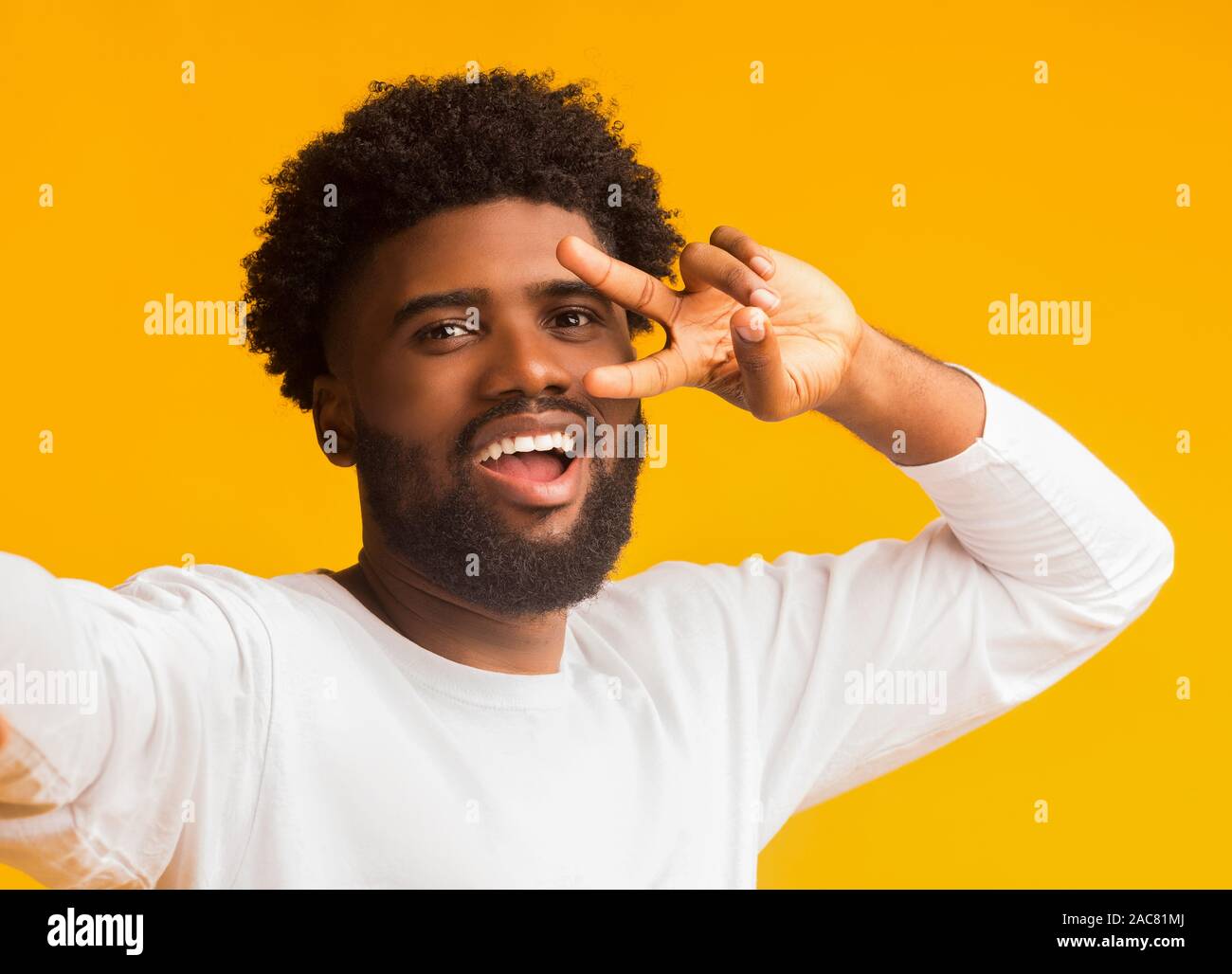 Happy black man holding camera and making selfie Stock Photo - Alamy