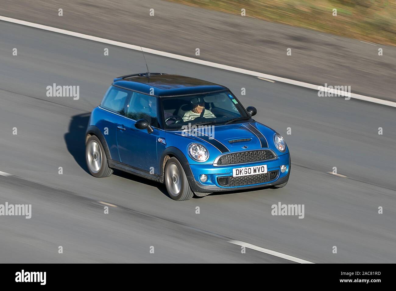 Blurred moving car 2010 BLUE MINI COOPER S traveling at speed on the ...