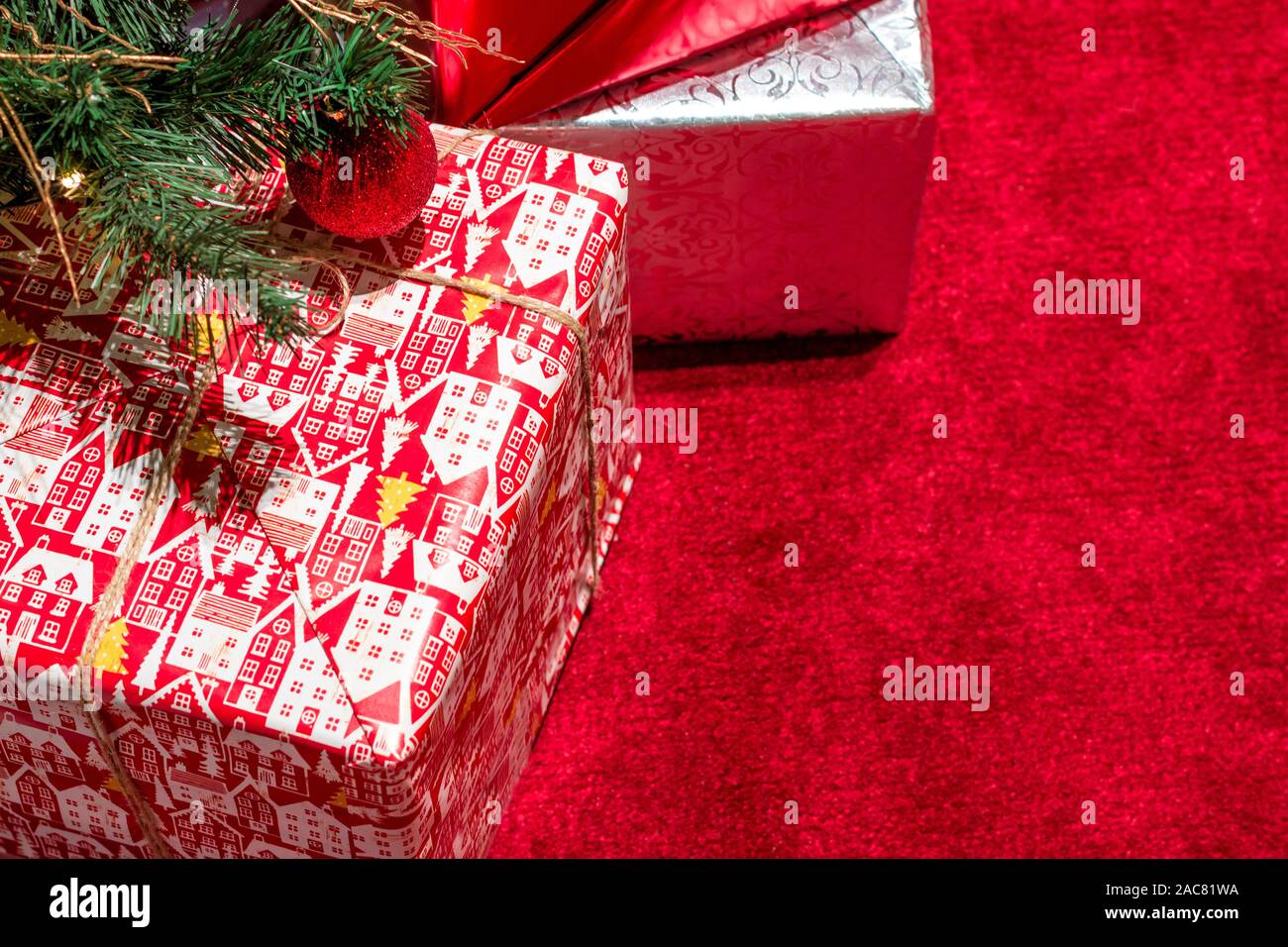 Different Christmas gift boxes under the fir tree on a red carpet Stock ...