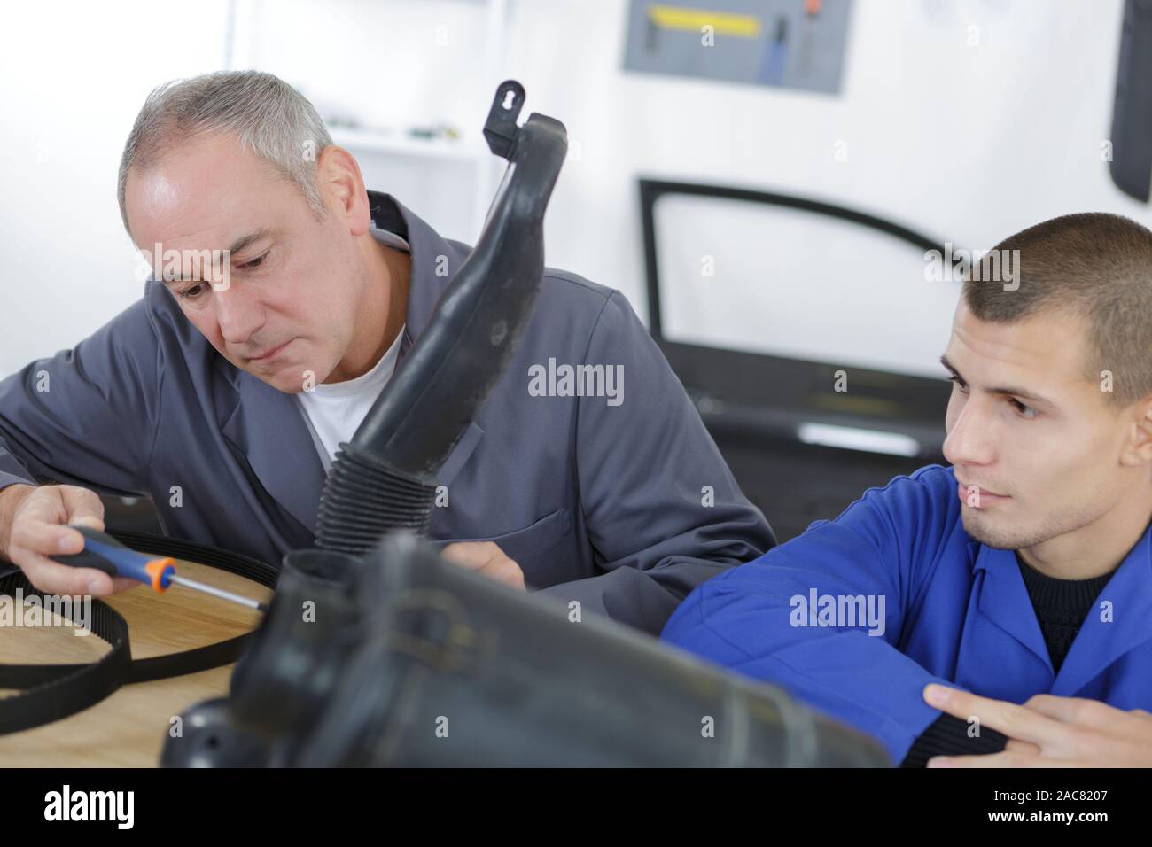 apprentice mechanic holding engine block Stock Photo - Alamy