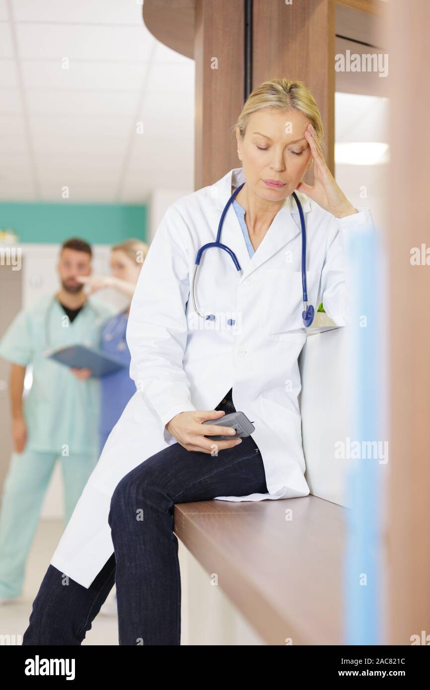 mature female doctor with her head in her hand Stock Photo - Alamy