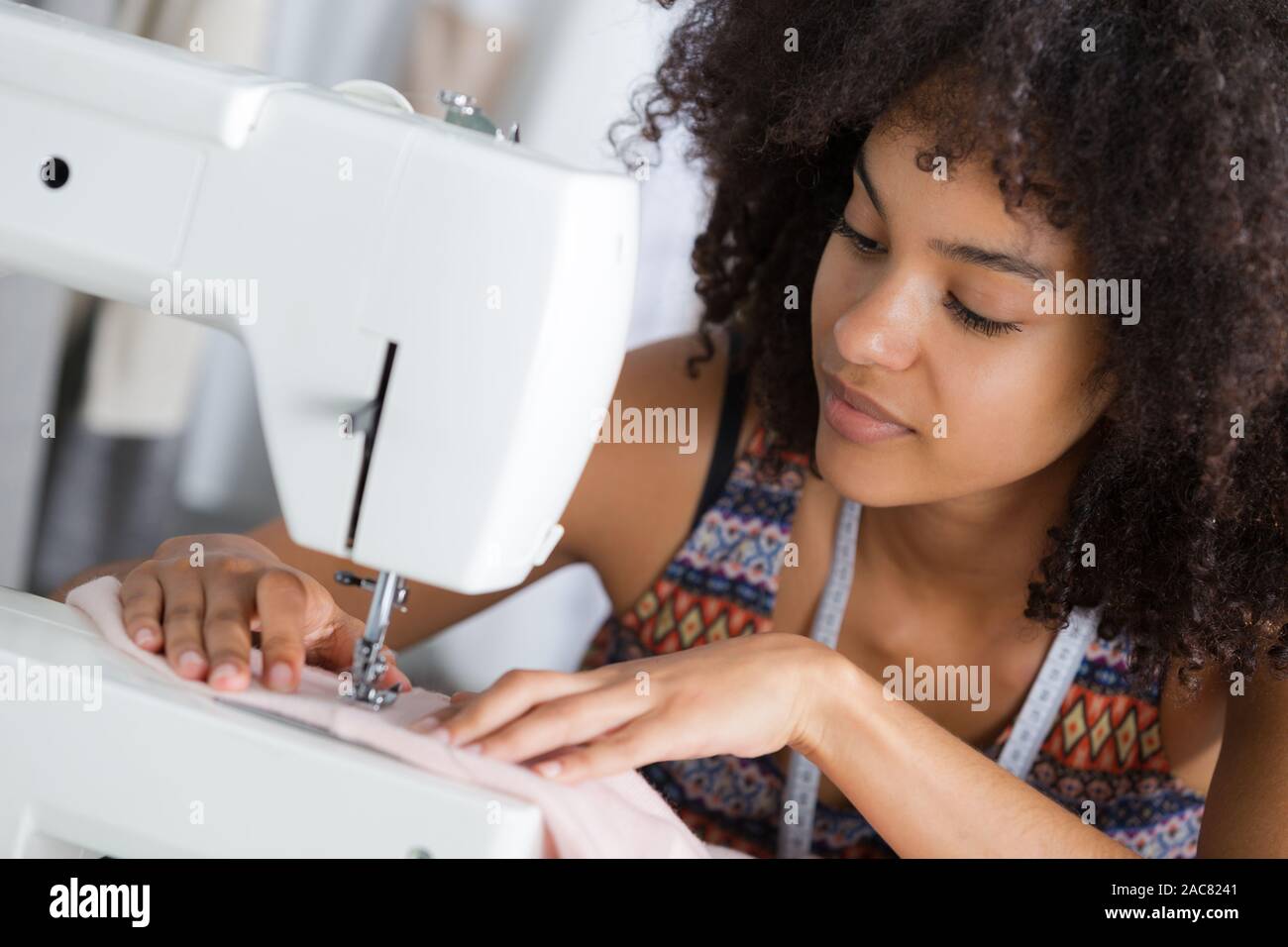female tailor sews clothes on the sewing machine Stock Photo - Alamy