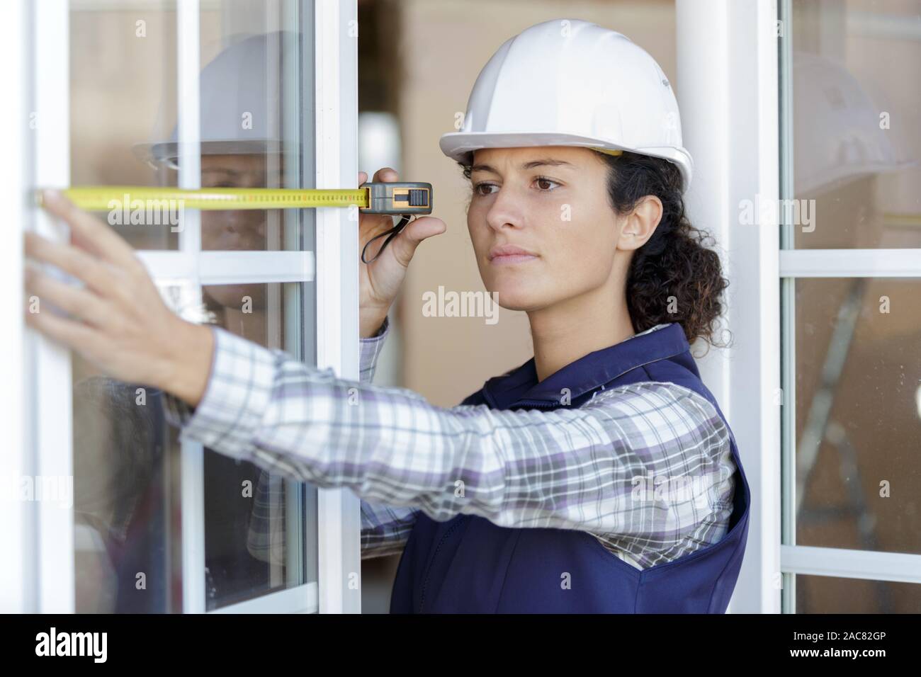 a woman builder measuring window Stock Photo - Alamy