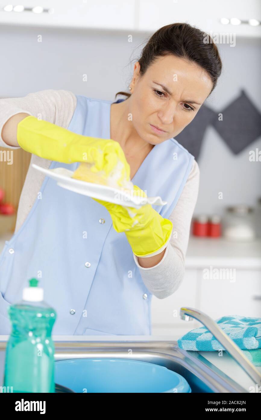 upset housewife woman washing dishes in kitchen Stock Photo - Alamy