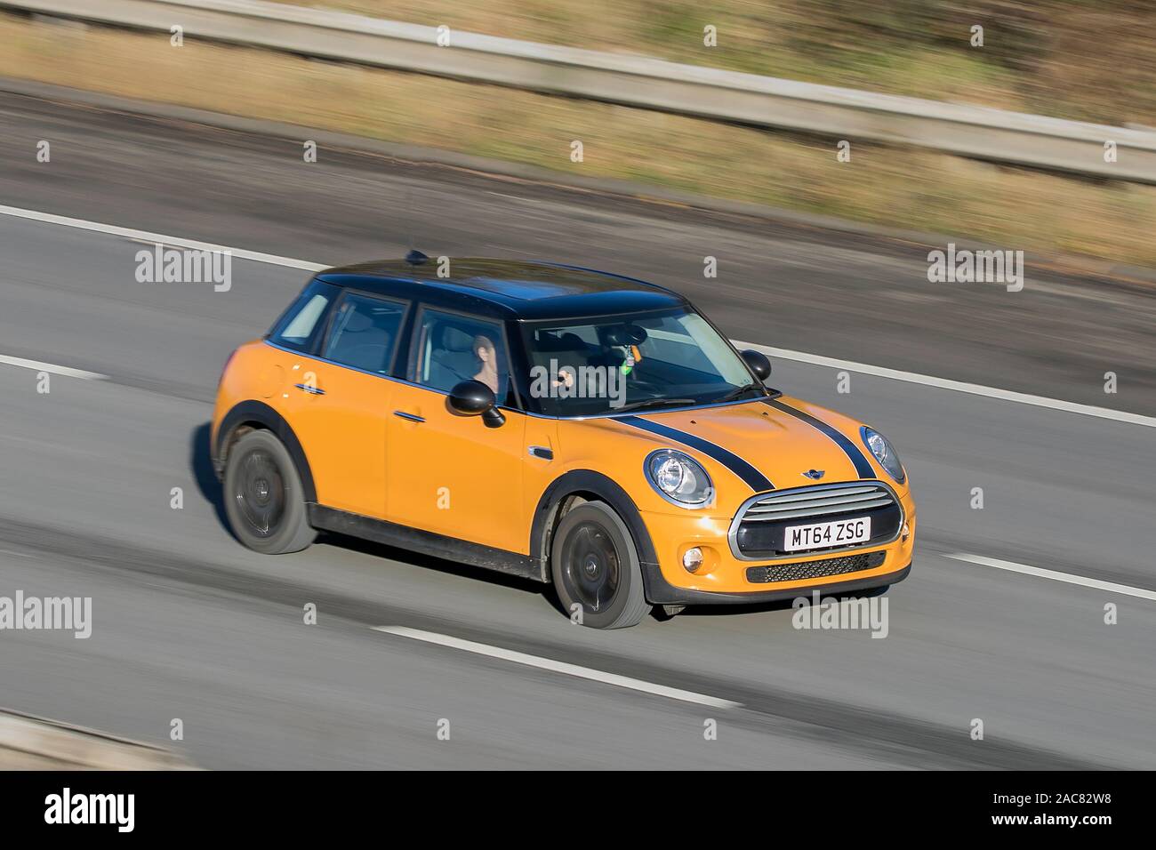 Blurred moving car 2014 MINI COOPER traveling at speed on the M61 ...