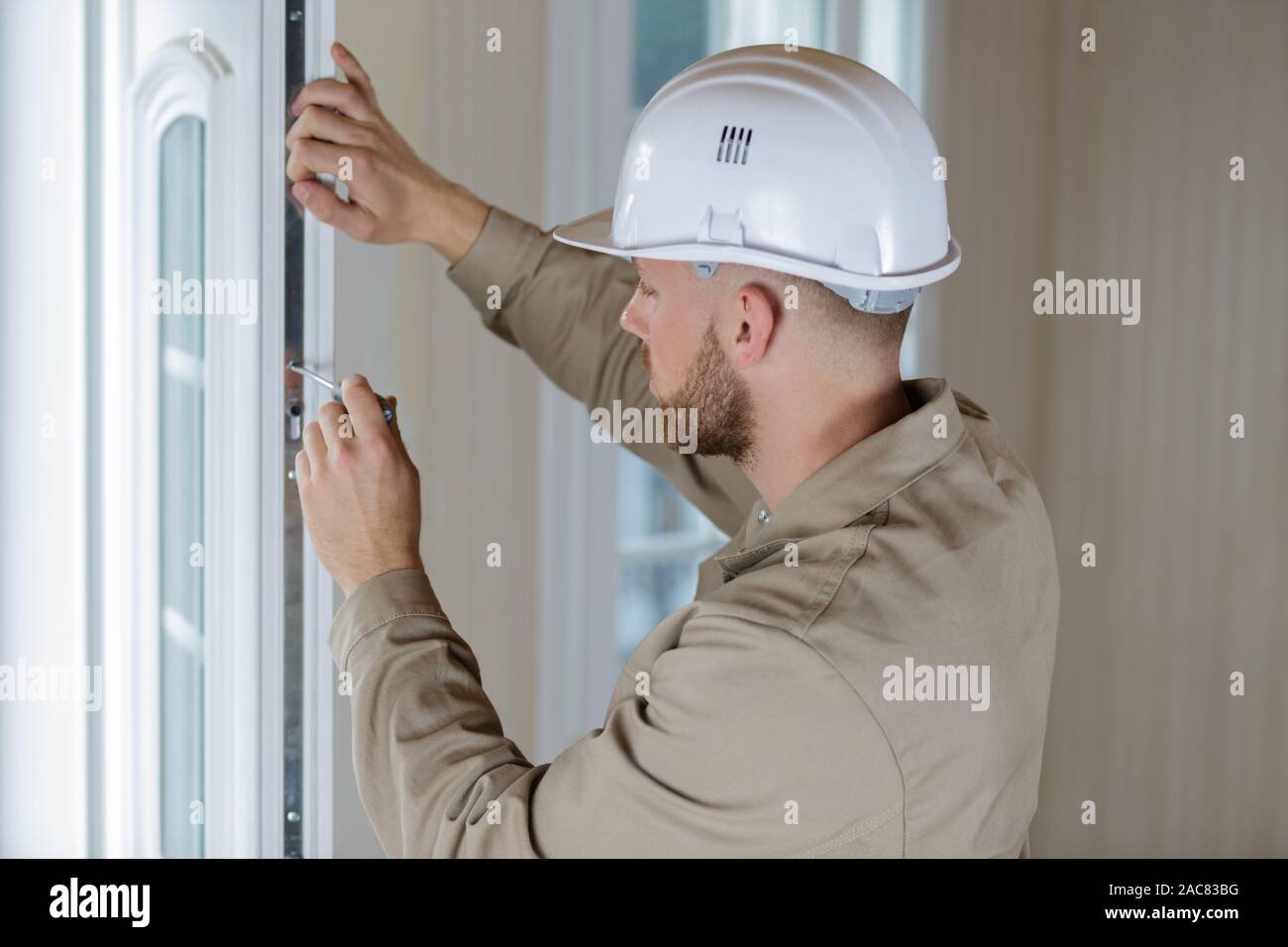 worker screws screw with a screwdriver Stock Photo - Alamy