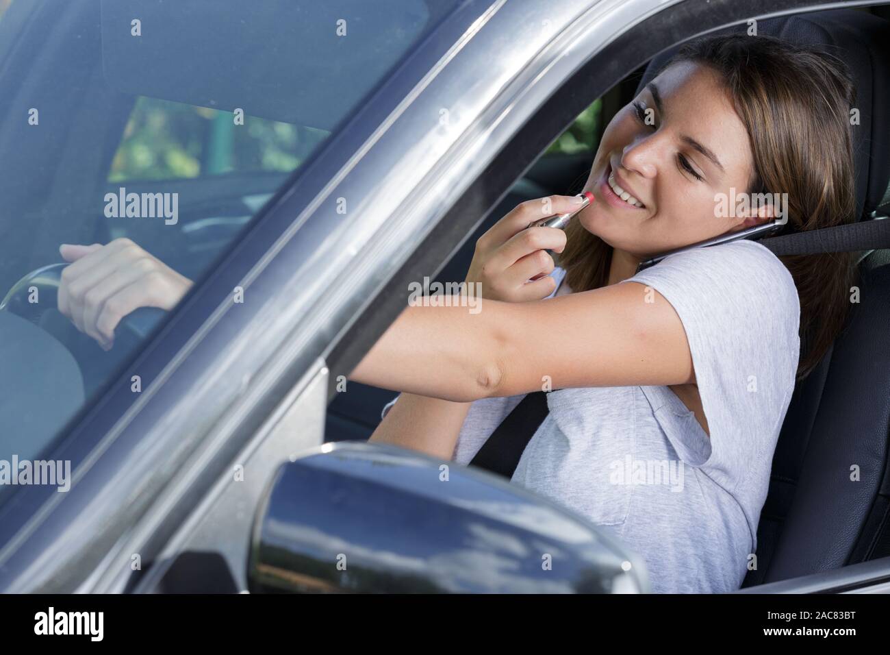 woman putting on lipstick in a car Stock Photo - Alamy