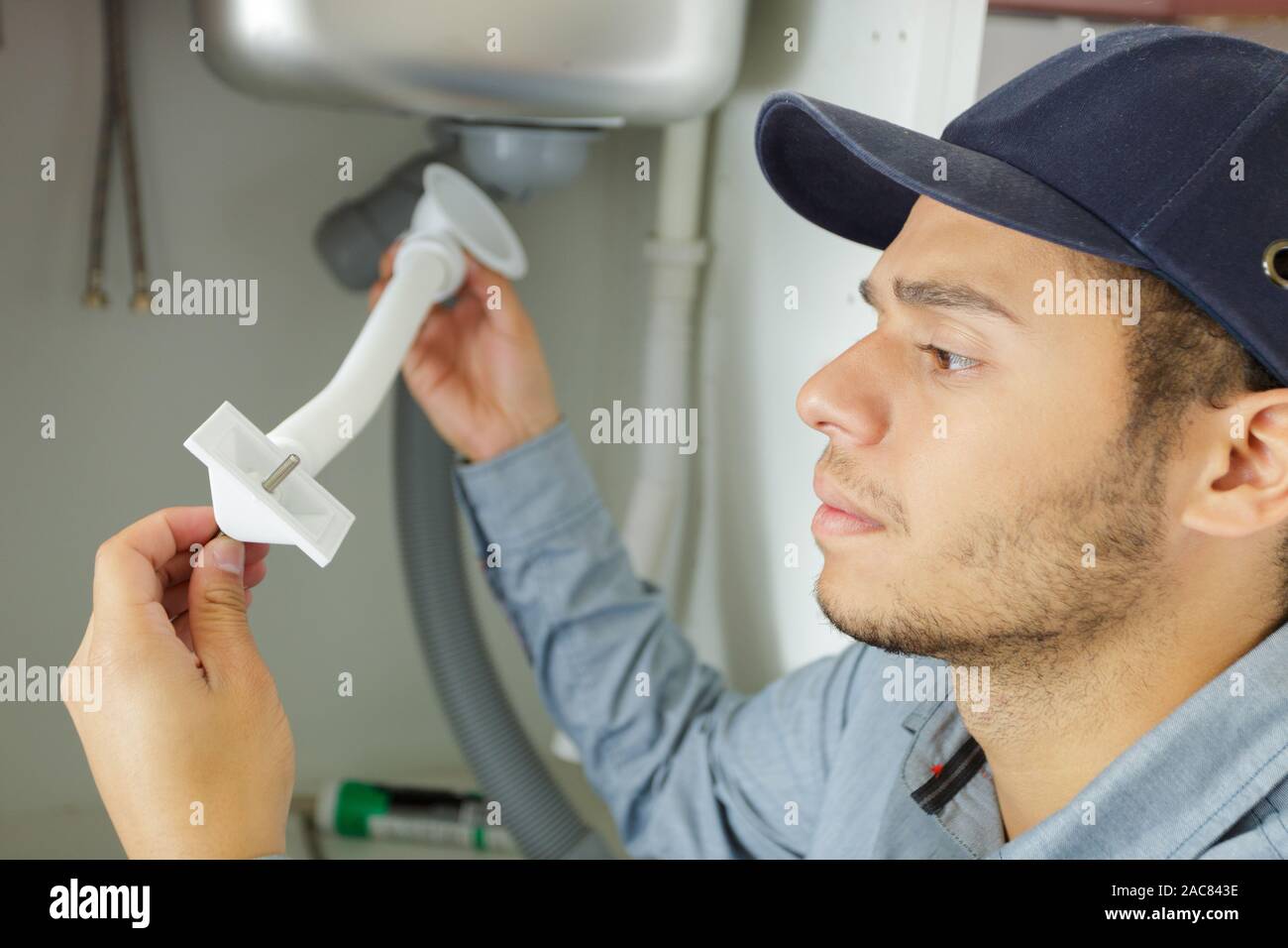man fixing pipes under the sink Stock Photo - Alamy