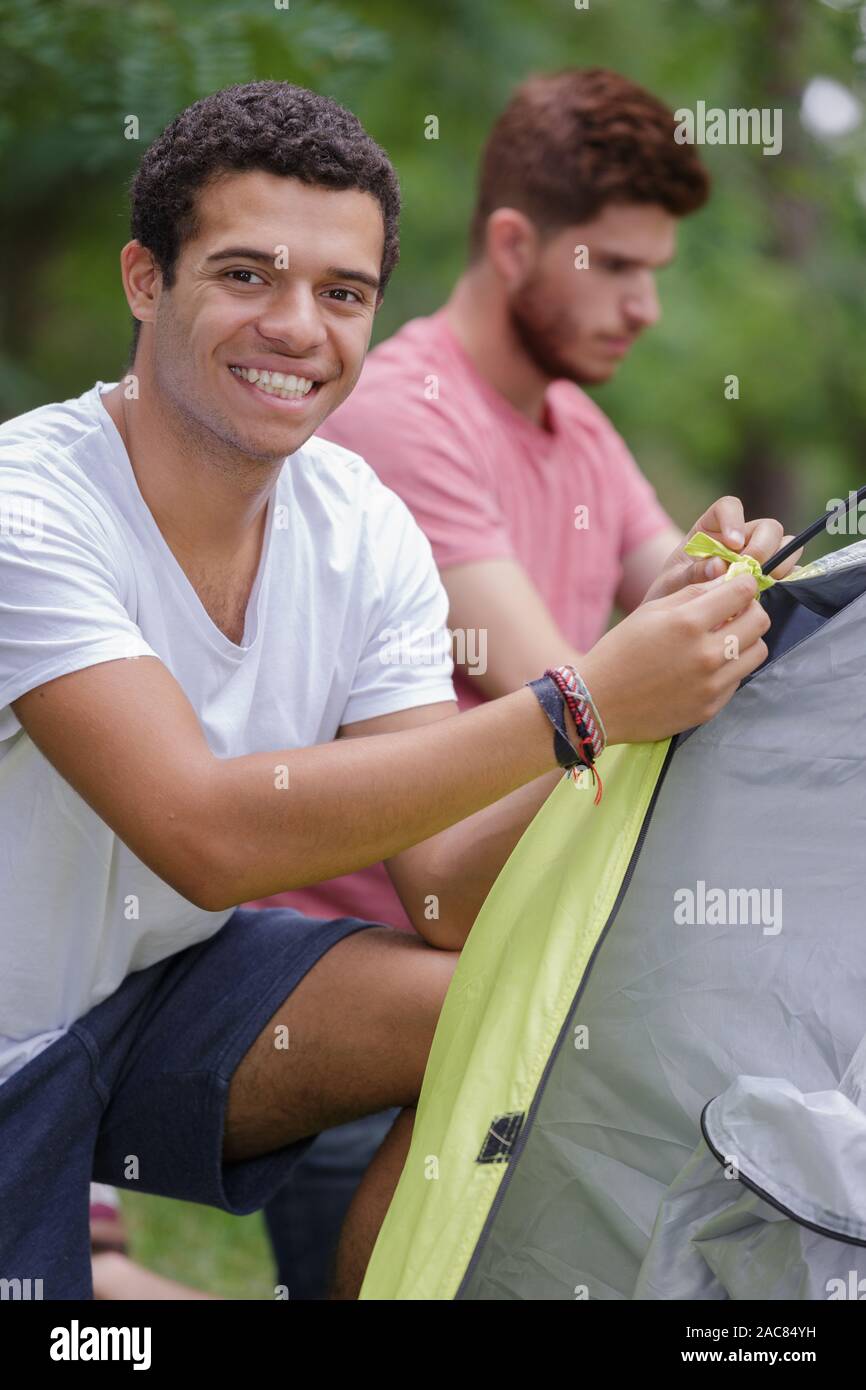 men setting up a tent in the forest camp Stock Photo - Alamy