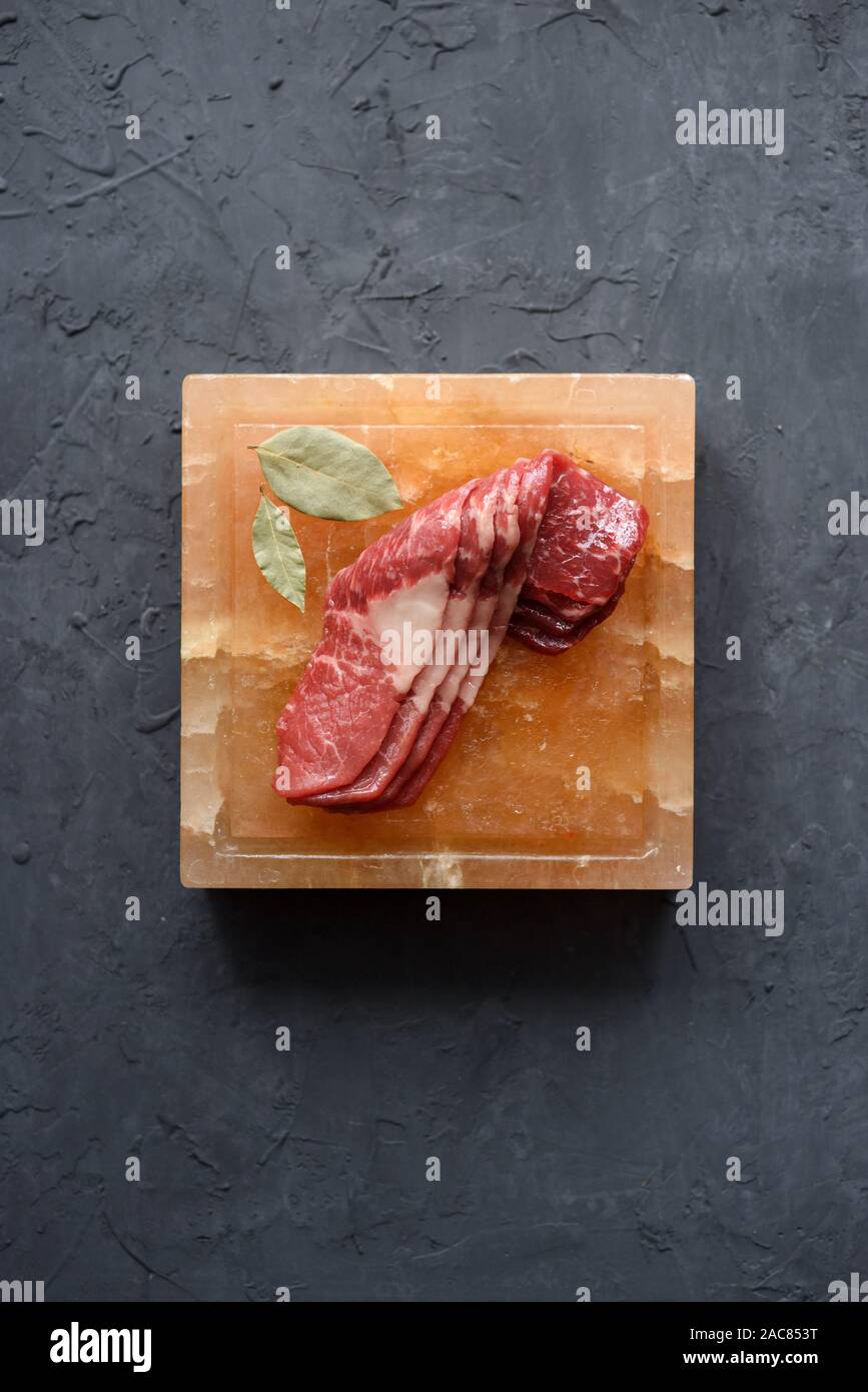 Salt block cooking. Thin slices of Black Angus beef on big Himalayan ...
