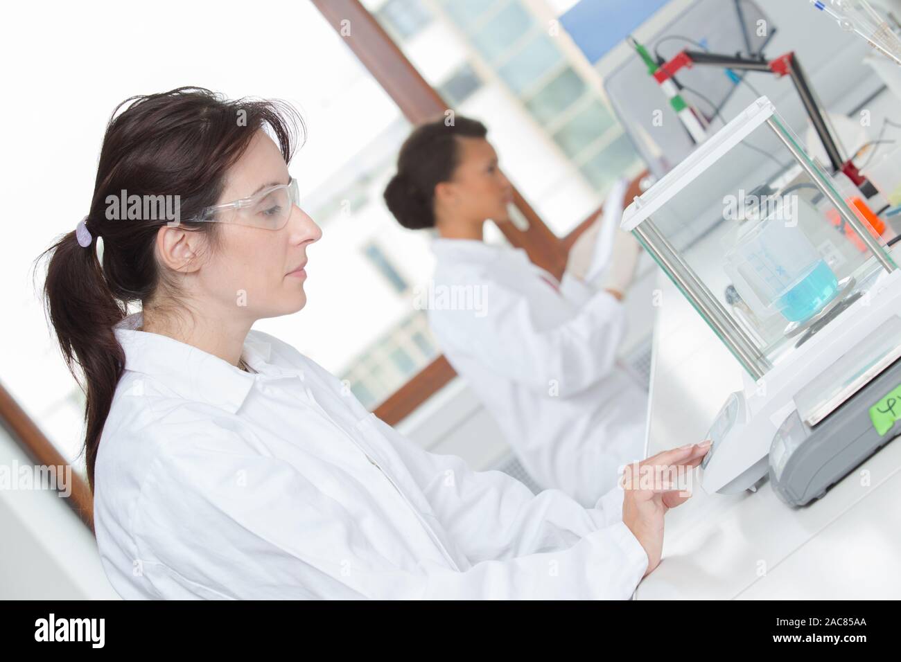 women working in laboratory using scales Stock Photo - Alamy