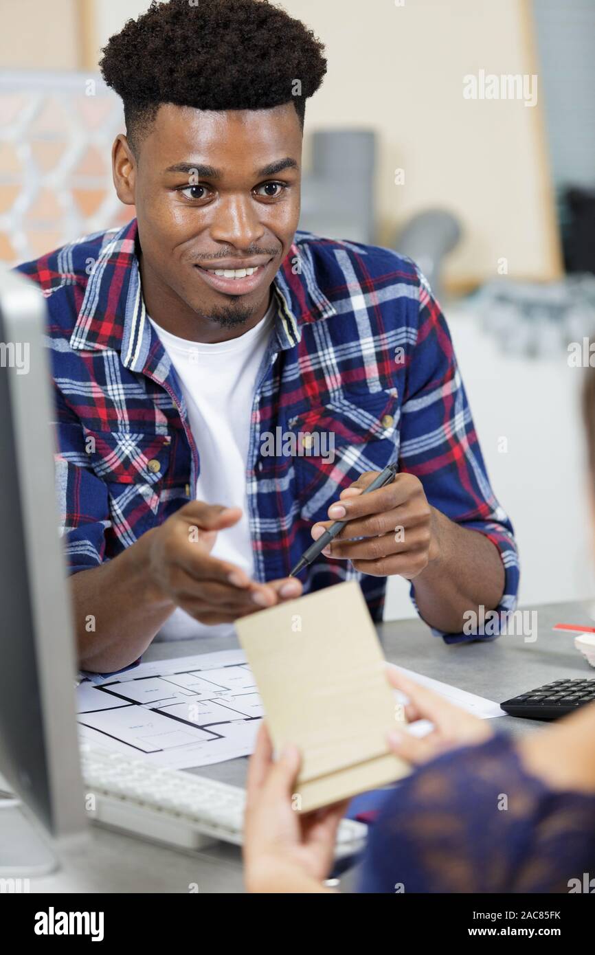 confident interior designer studying floor plan while talking to ...