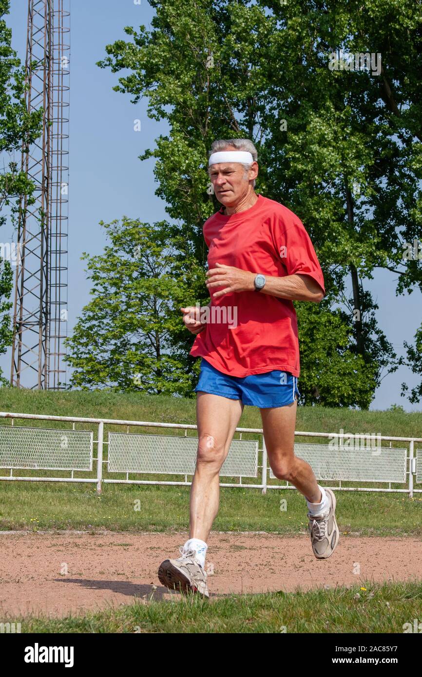 Senior runner running on track and field Stock Photo - Alamy