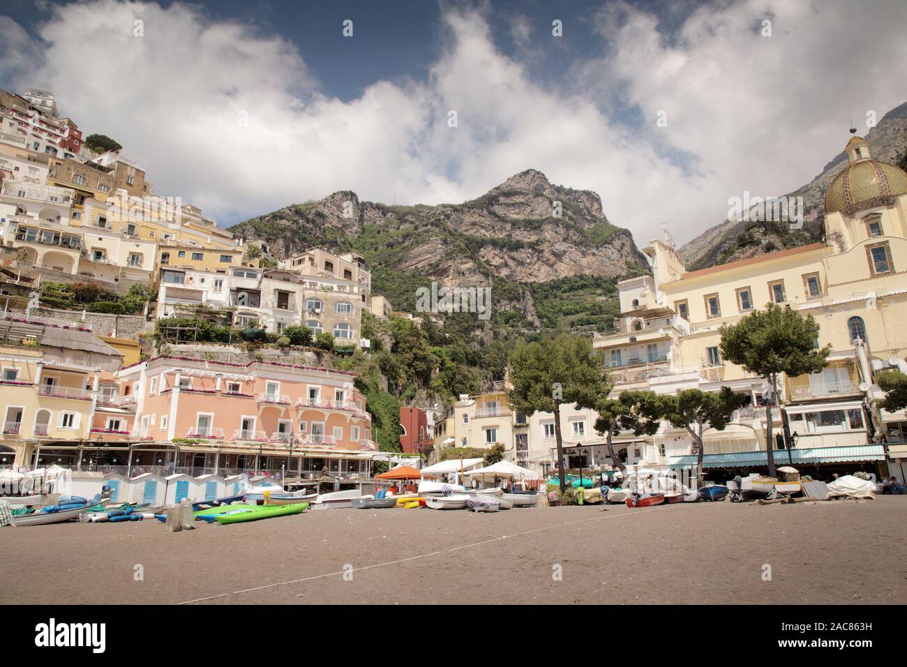beach on positano with all the house built on the side of the cliff ...