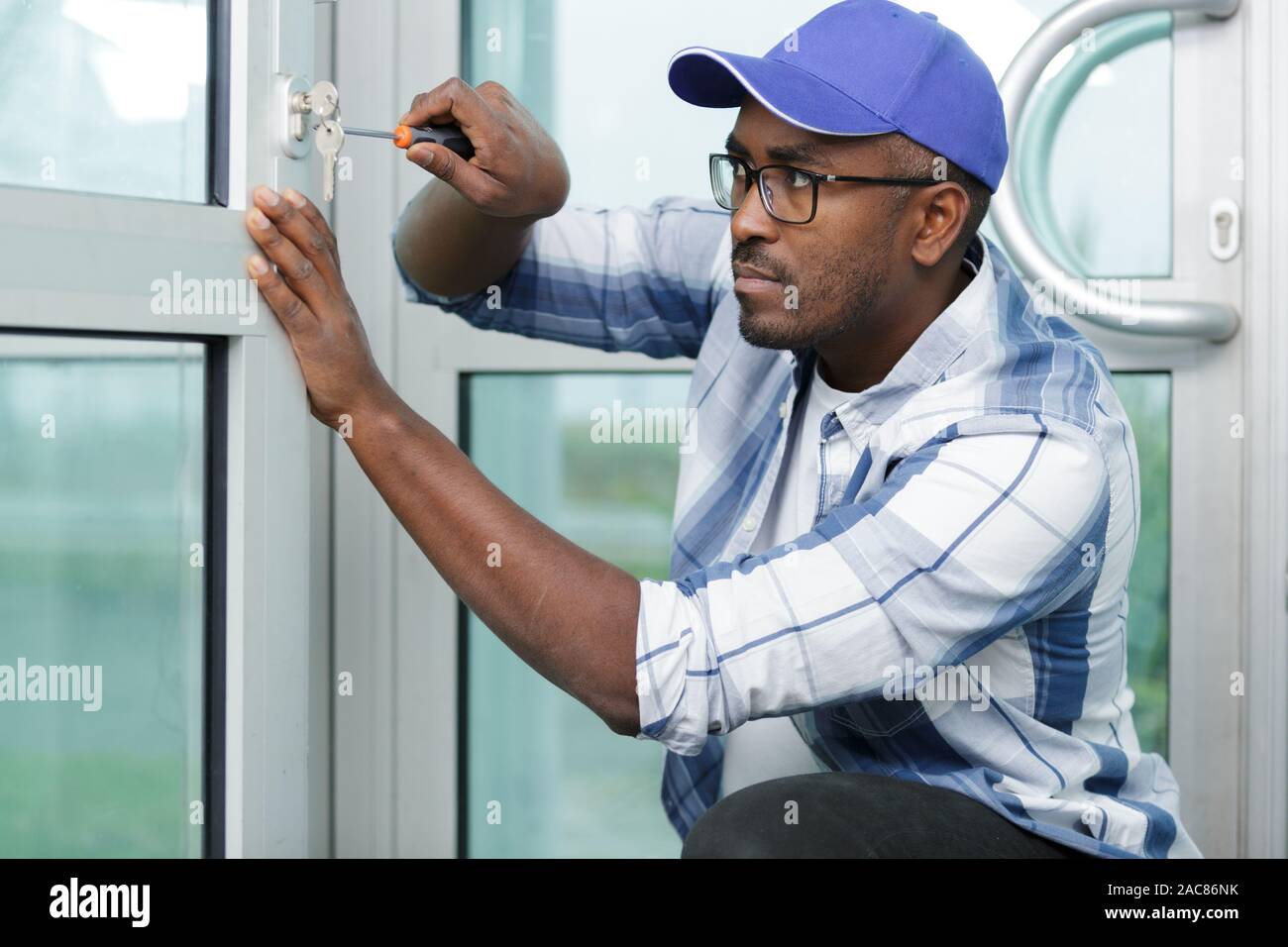 man working fittings on a window Stock Photo - Alamy
