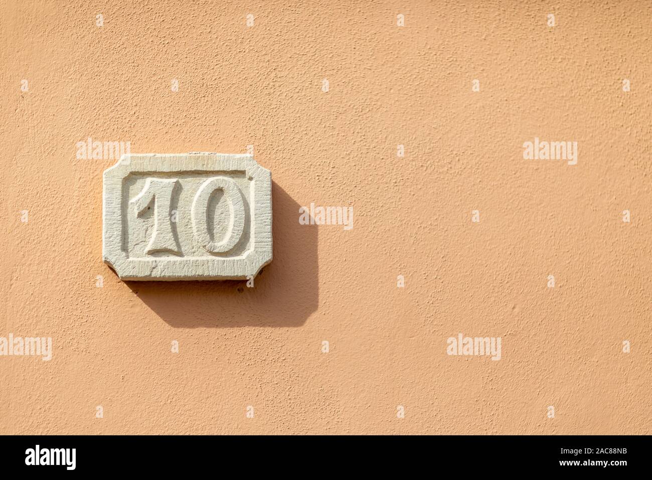 White number 10 on terracotta coloured wall Stock Photo - Alamy