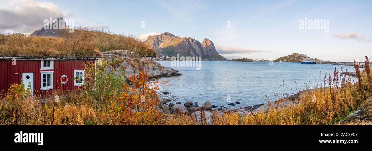 Traditional, red, wooden houses in Reine with the Reinebringen hill in ...