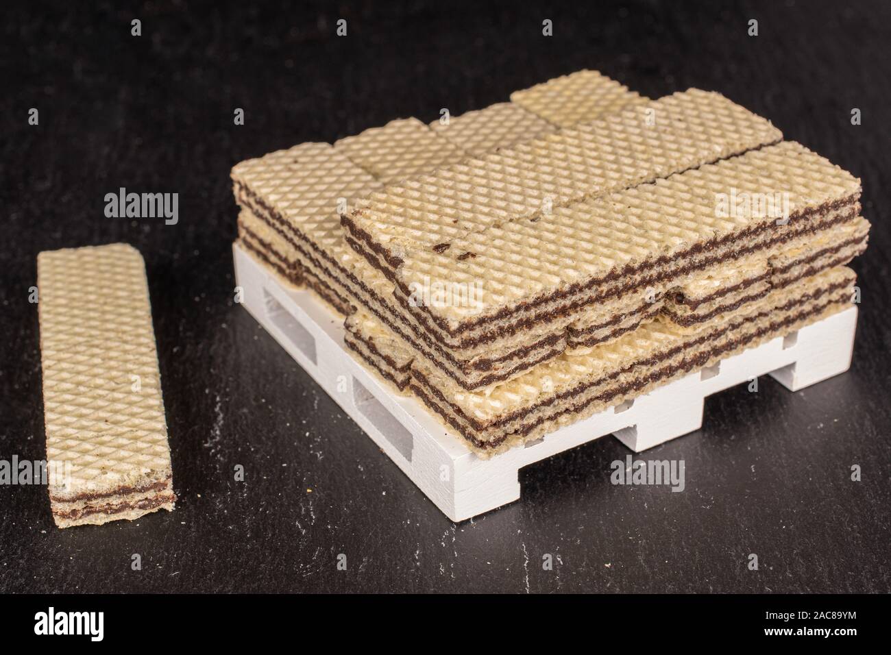 Lot of whole sweet chocolate biscuit wafer on white pallet on grey ...
