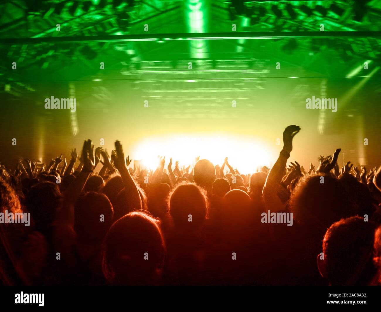 Photo of a concert hall with people silhouettes clapping in front of a ...