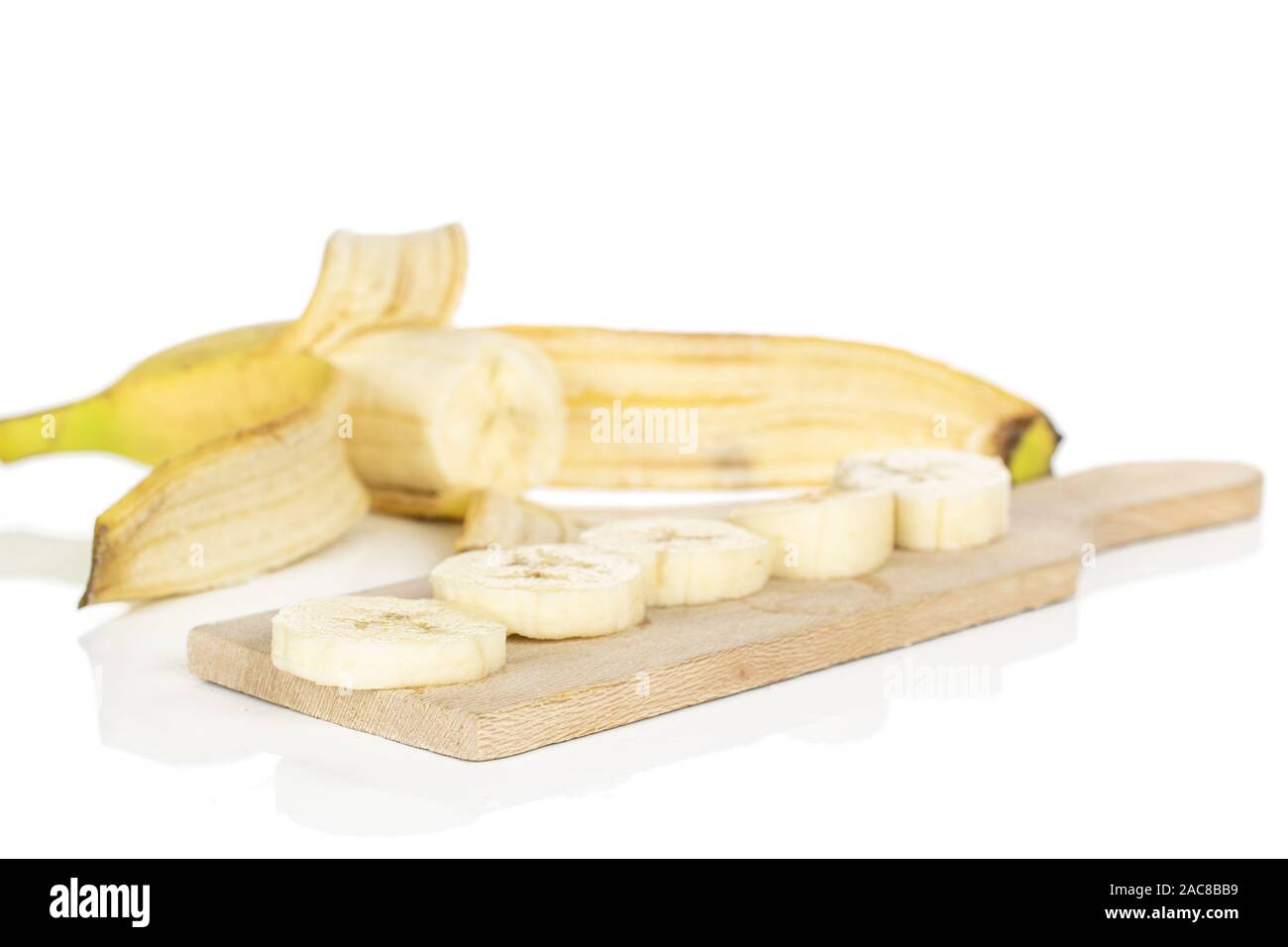 Group of one half five slices of open sweet yellow banana on wooden ...