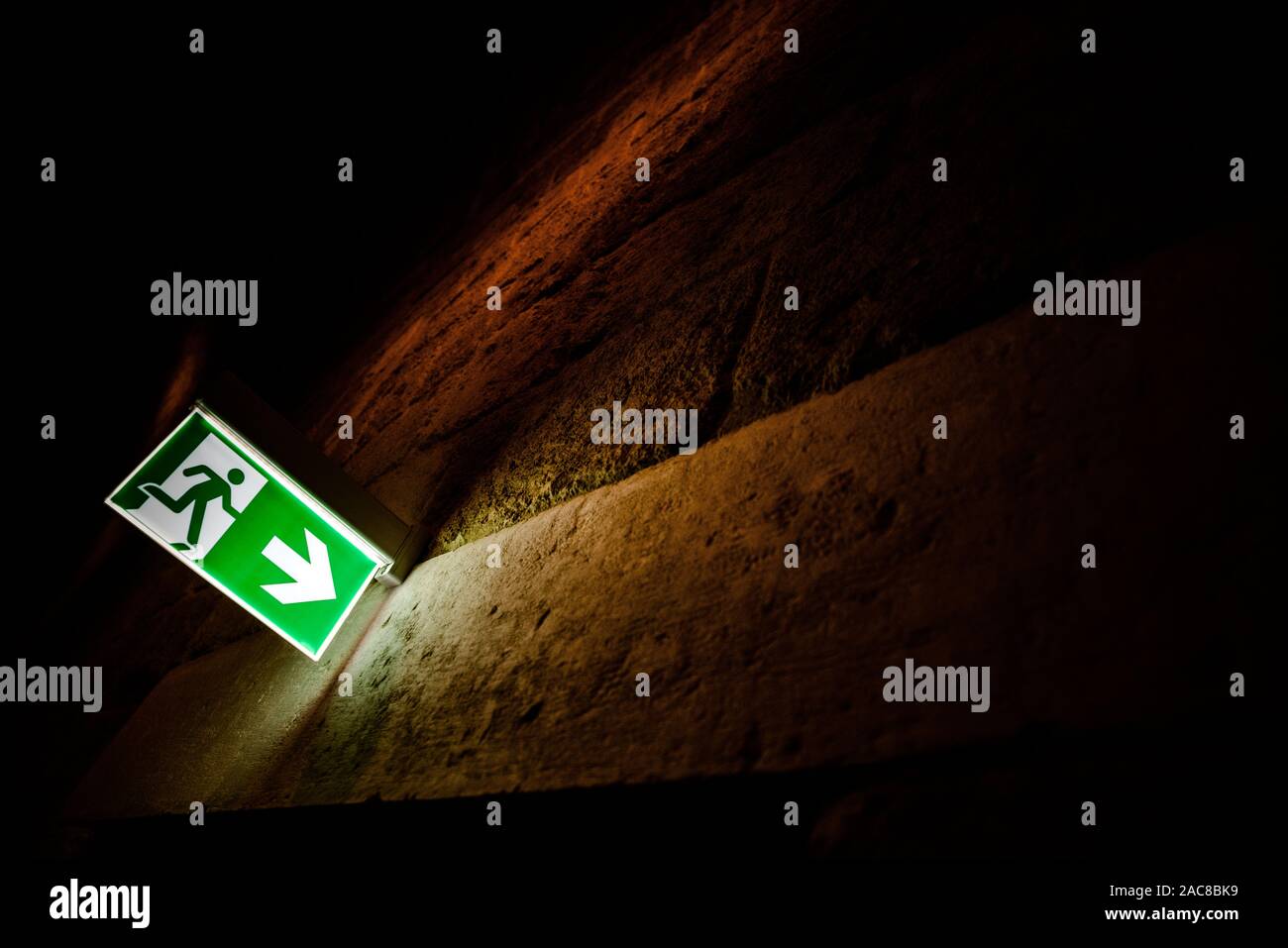 Emergency exit sign illuminated with dark background Stock Photo - Alamy