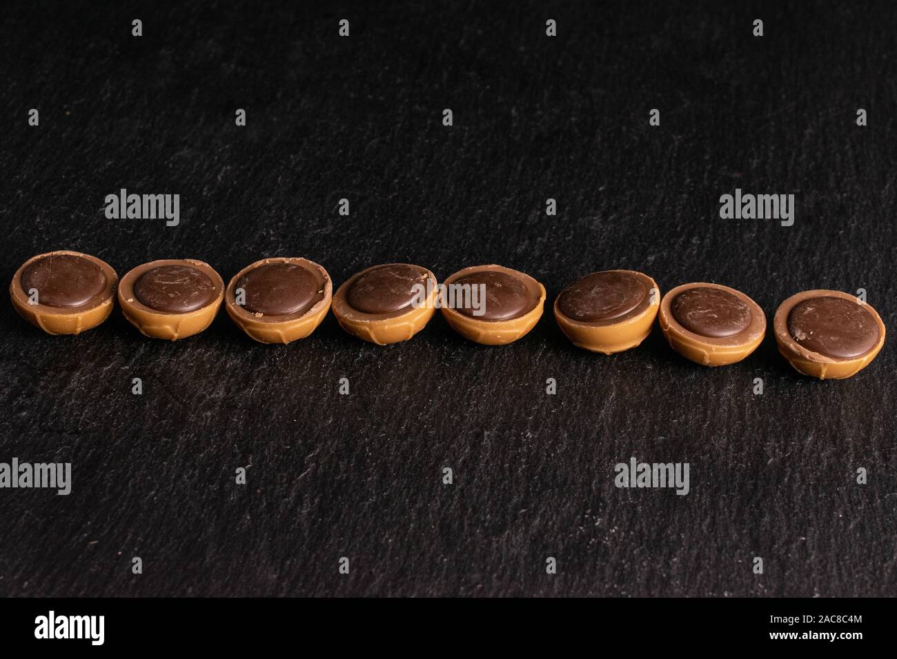 Group of eight whole sweet brown toffee in line on grey stone Stock ...