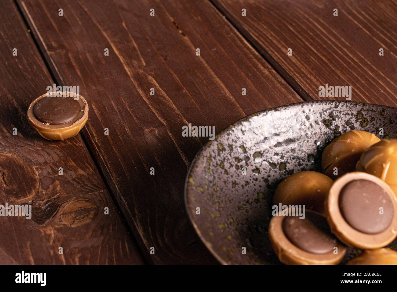 Lot of whole sweet brown toffee in glazed bowl on brown wood Stock ...