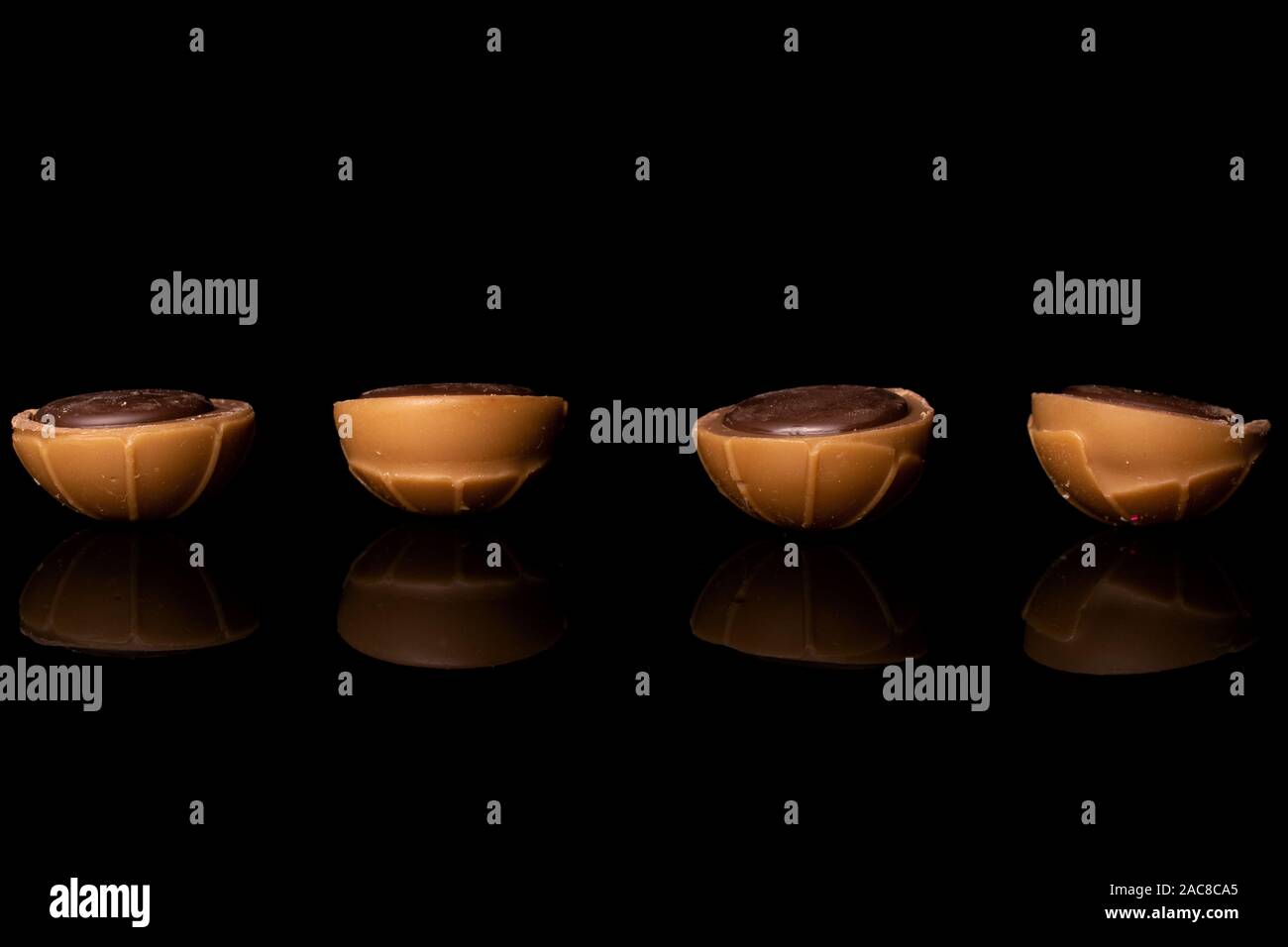 Group of four whole sweet brown toffee isolated on black glass Stock ...