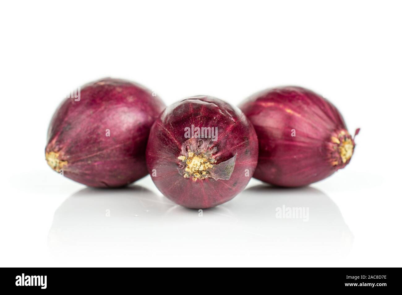 Group of three whole small red onion bulb in small group isolated on ...