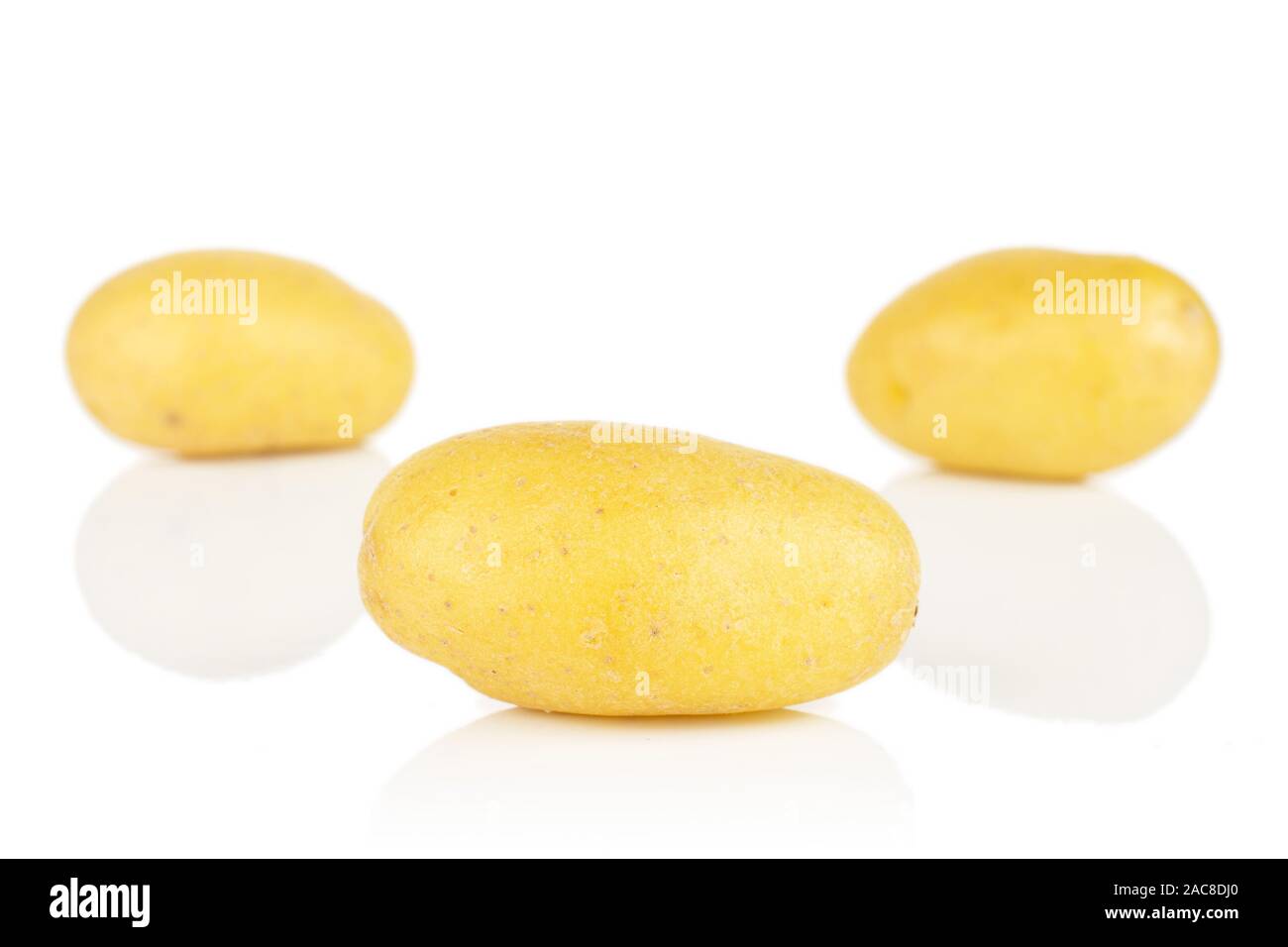 Group of three whole pale yellow potato isolated on white background ...