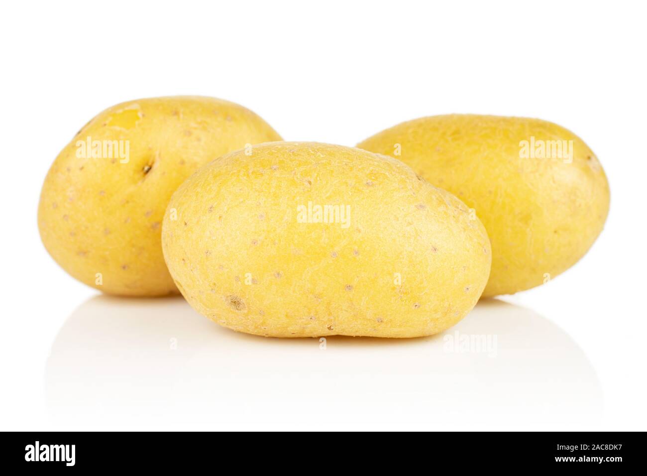 Group of three whole pale yellow potato isolated on white background ...