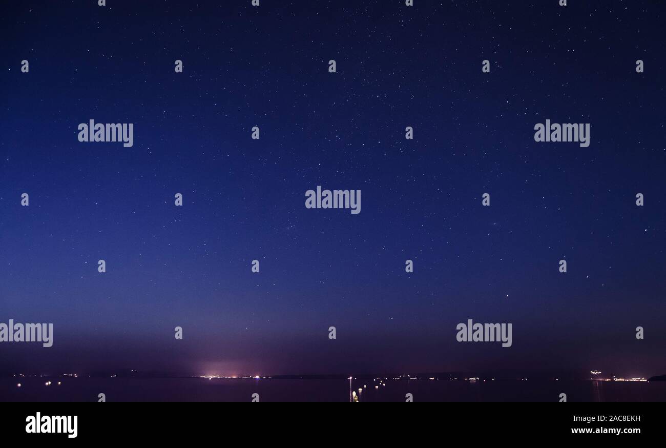Seascape at night with settlement lights in the distance Stock Photo ...