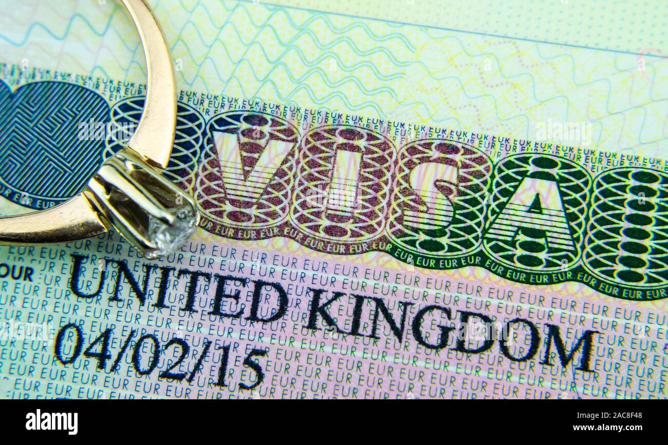 UK Visa sticker in a passport and the engagement diamond ring placed on ...