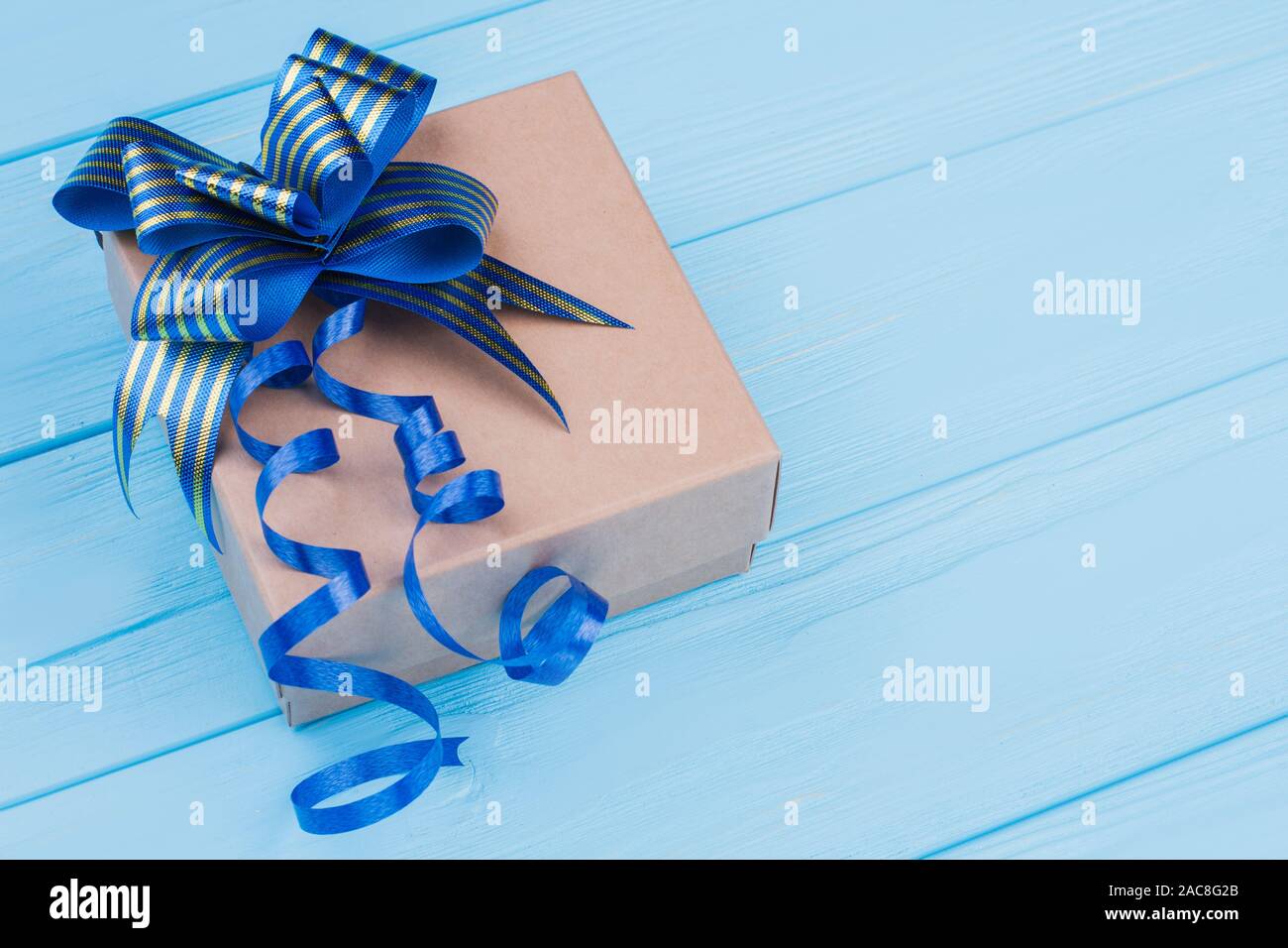 Brown craft box with blue striped ribbon bow Stock Photo - Alamy