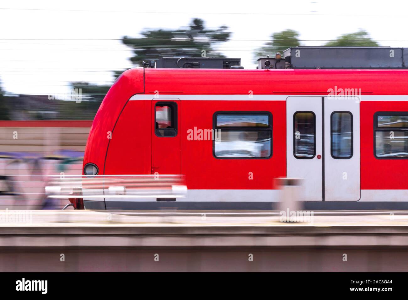 passenger tram train speeding through a station Stock Photo - Alamy