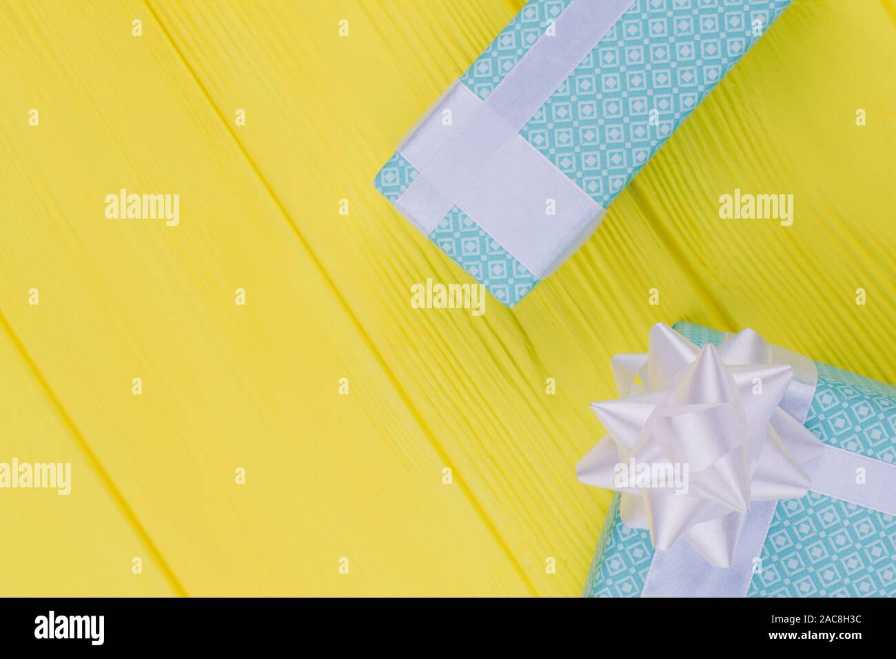Turquoise gift boxes on yellow background Stock Photo - Alamy