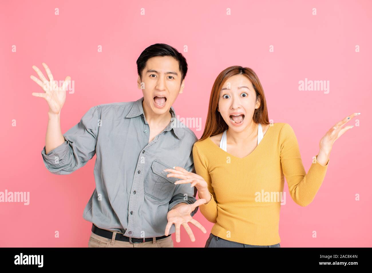 Portrait of surprised young couple standing together Stock Photo - Alamy