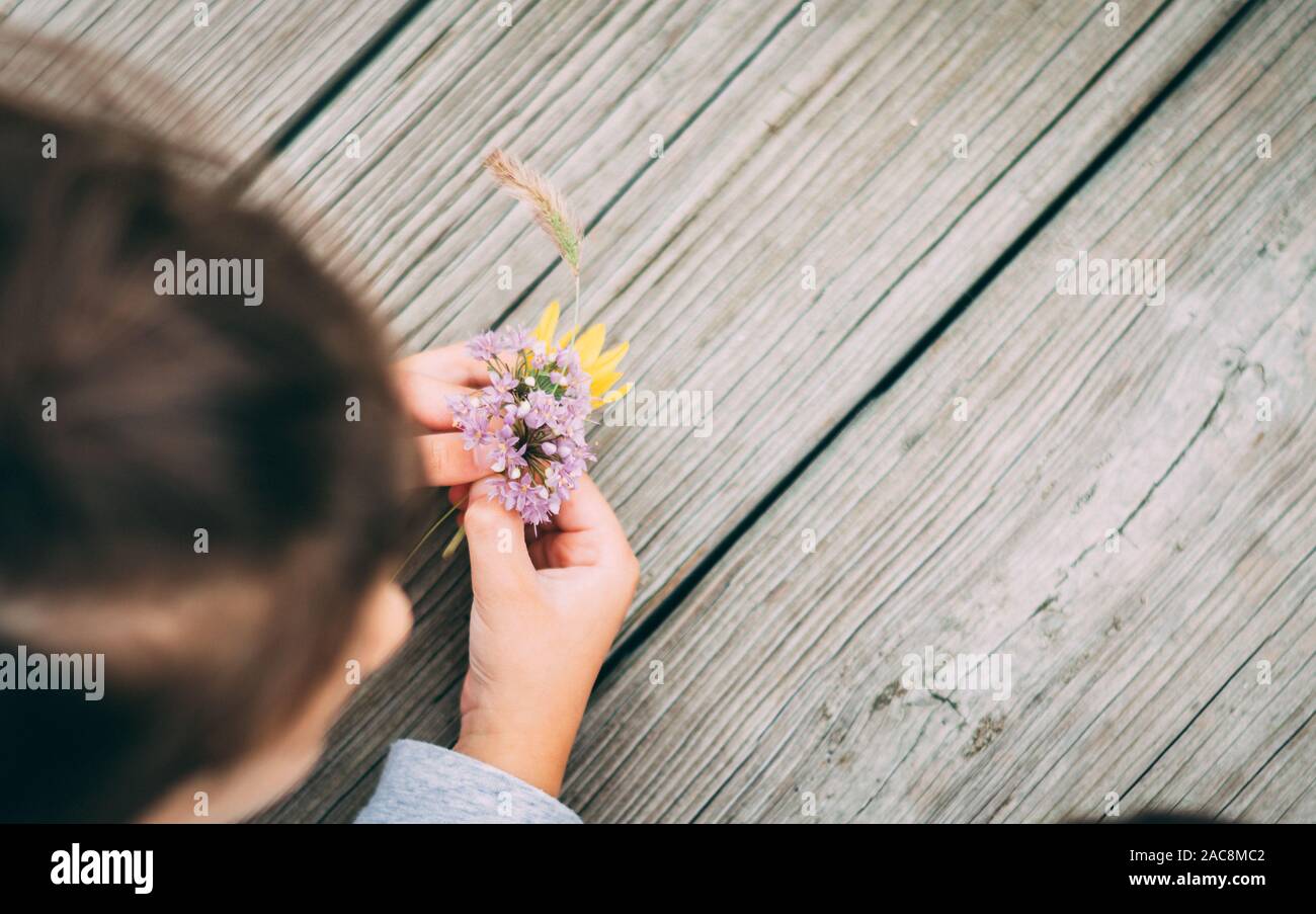 young girl playing with flowers on the dock Stock Photo - Alamy