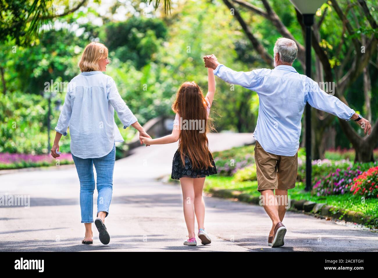Happy healthy family walk together on path in the park in summer ...