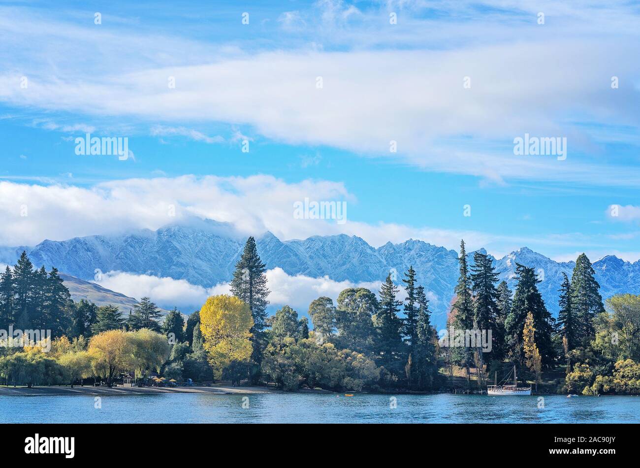 The forested shoreline of Queenstown in New Zealand from Lake Wakatipu ...