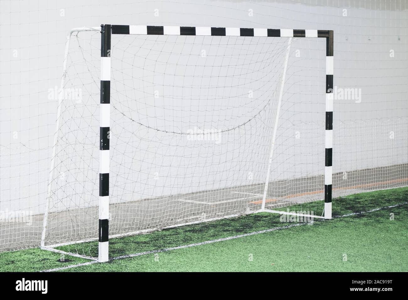 Football gates and net against white wall on green field at stadium for ...