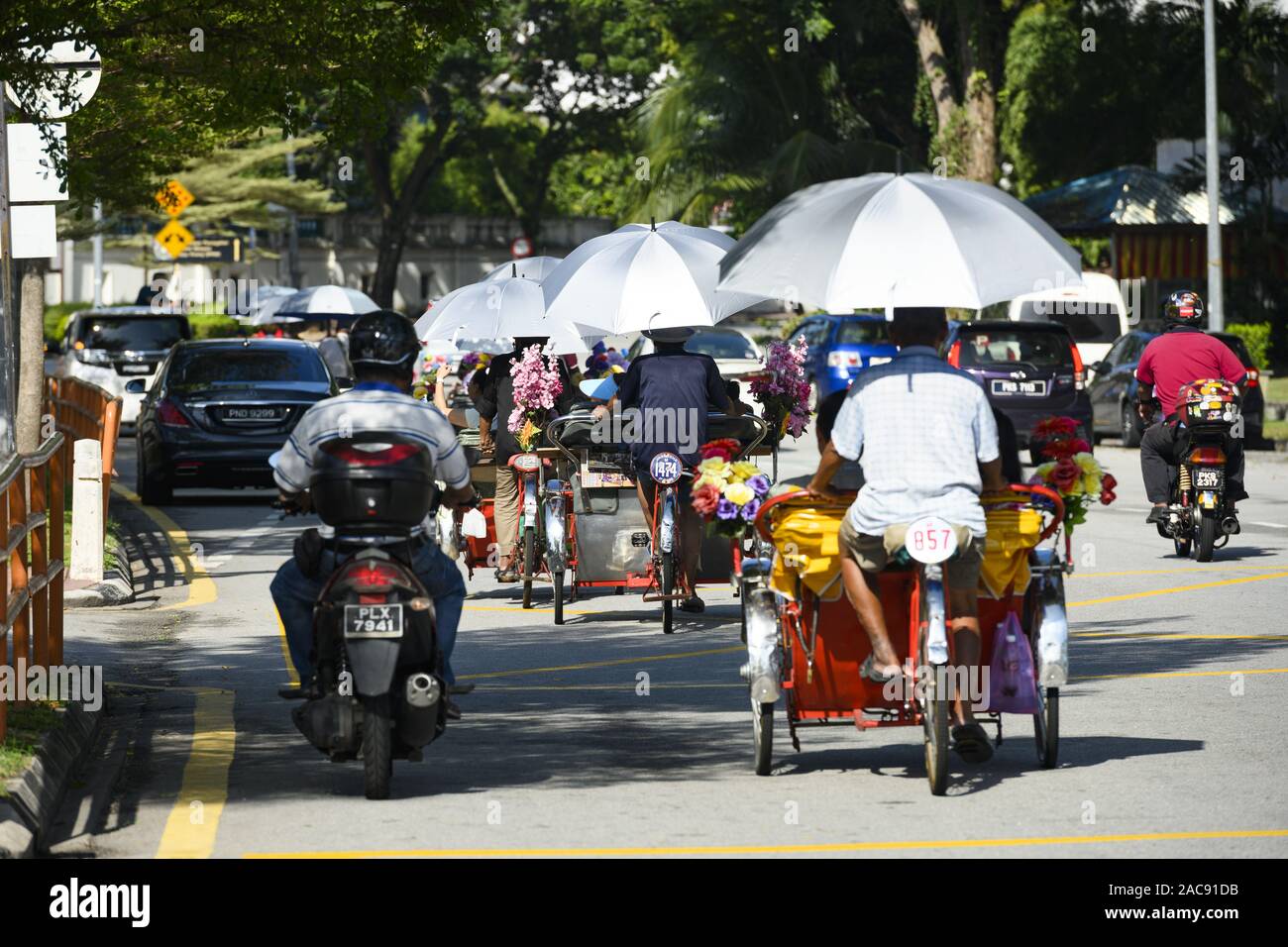 Some Trishaw drivers are driving through the streets of George Town ...