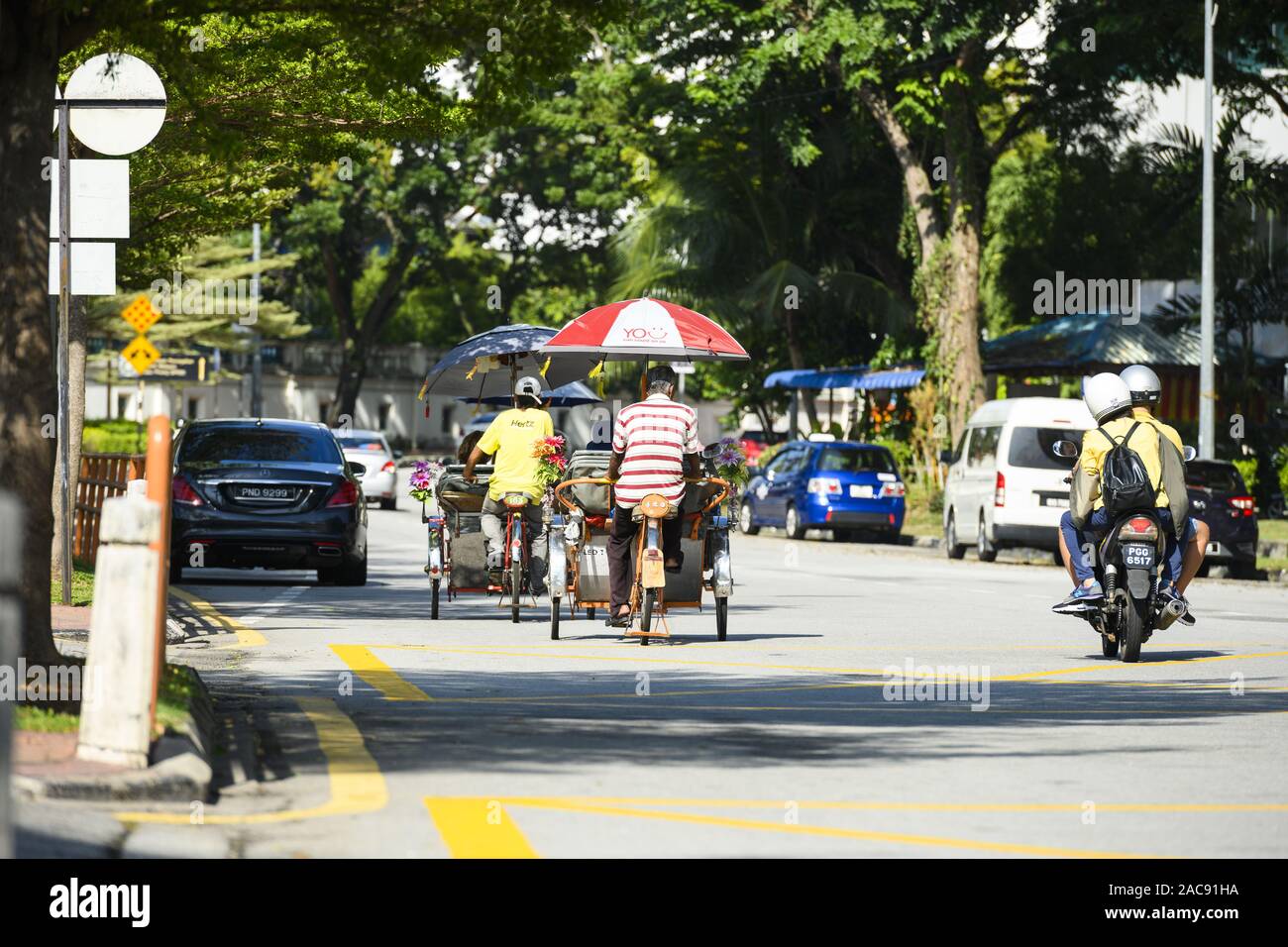 Some Trishaw drivers are driving through the streets of George Town ...